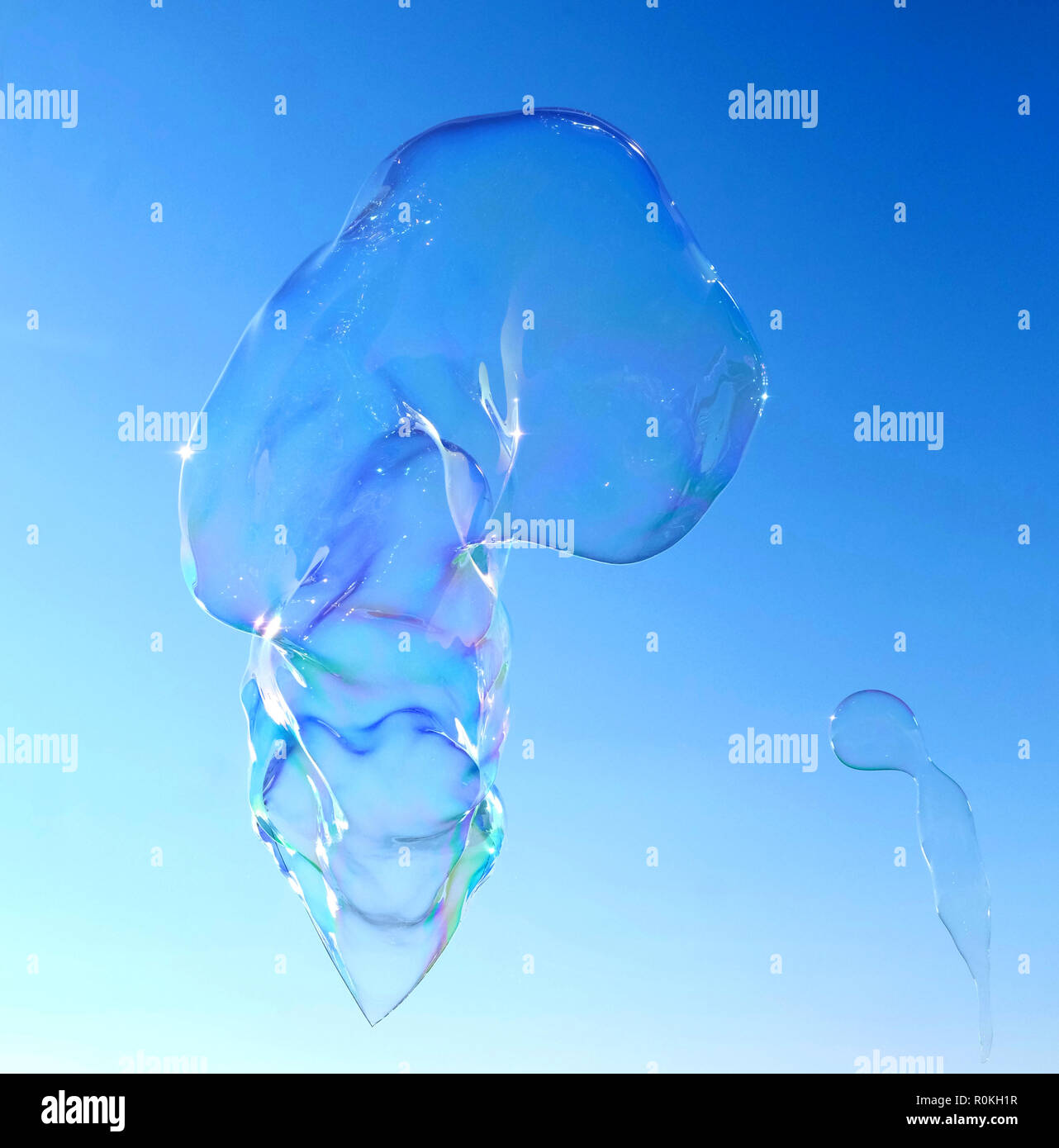 A big bubble floating in the sky, the sky is bright blue behind, the ...