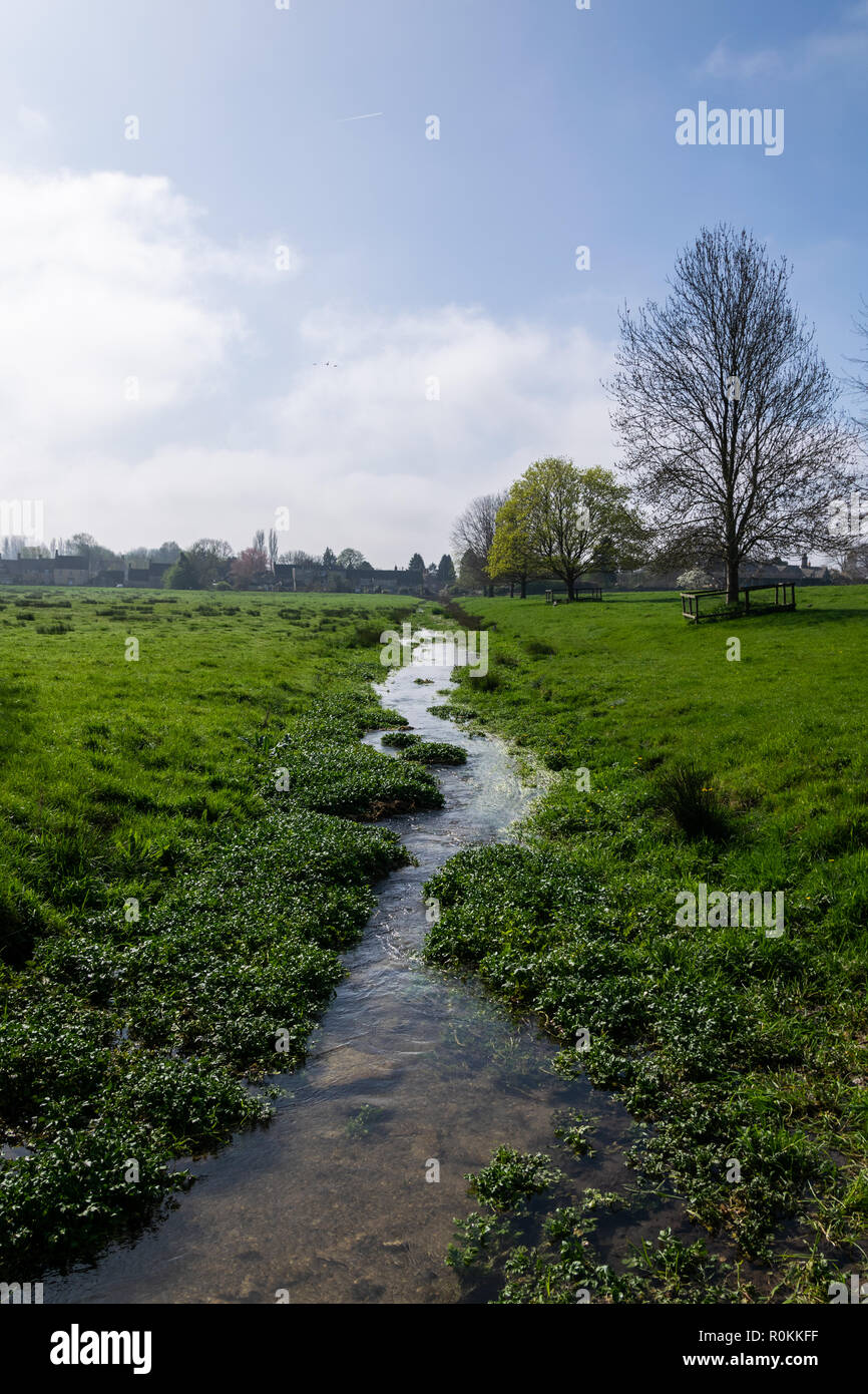 A shallow stream running across fields in winter Stock Photo - Alamy
