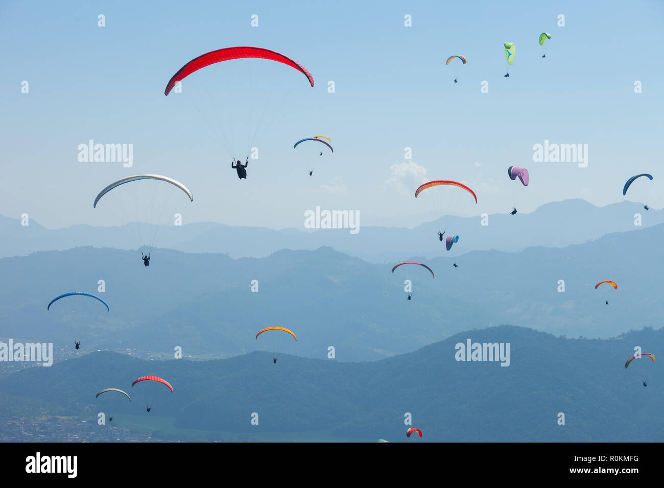 A large group of paragliders enjoy a thermal updraft in the Nepal ...