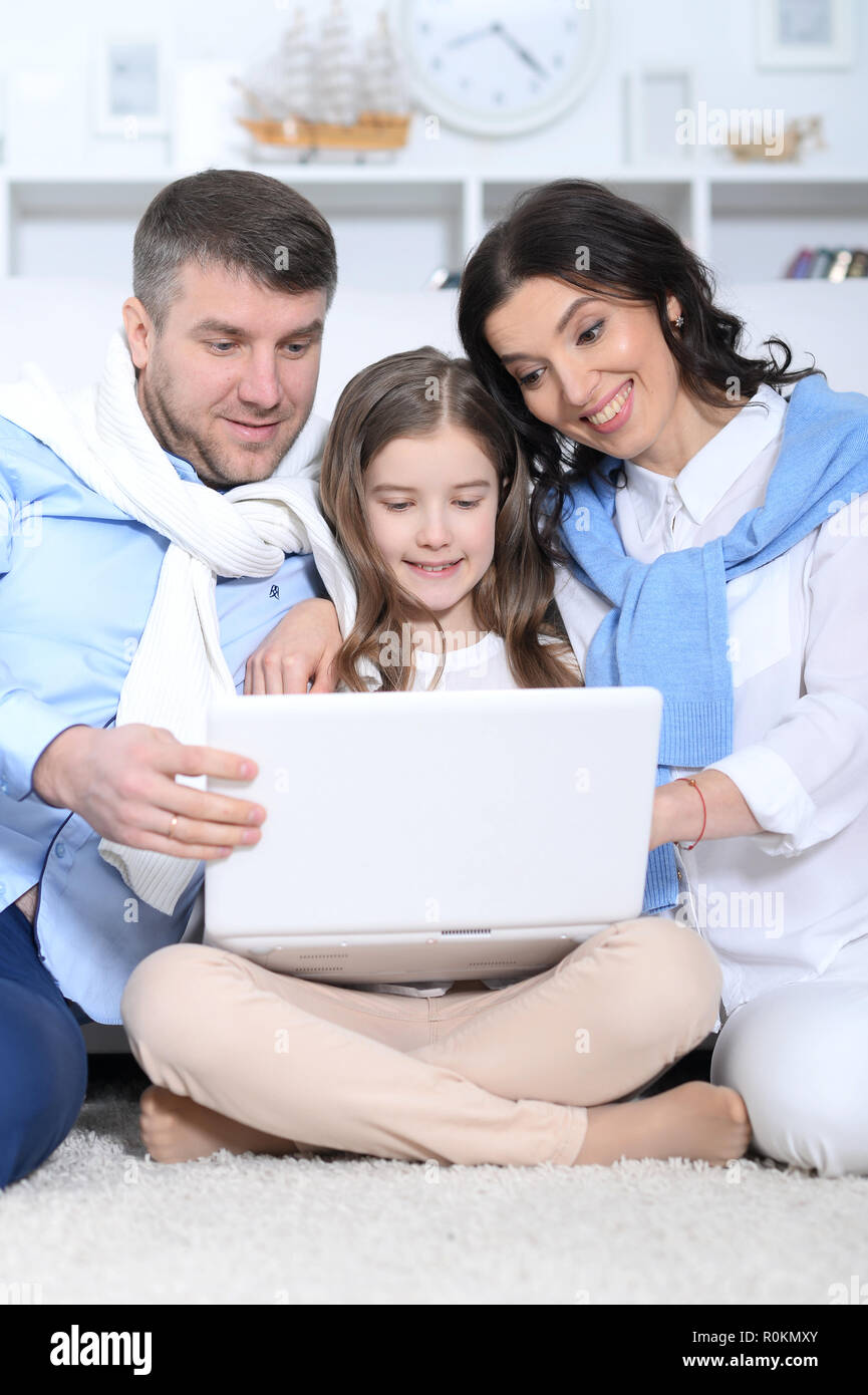 Portrait of parents and daughter using laptop in room Stock Photo - Alamy