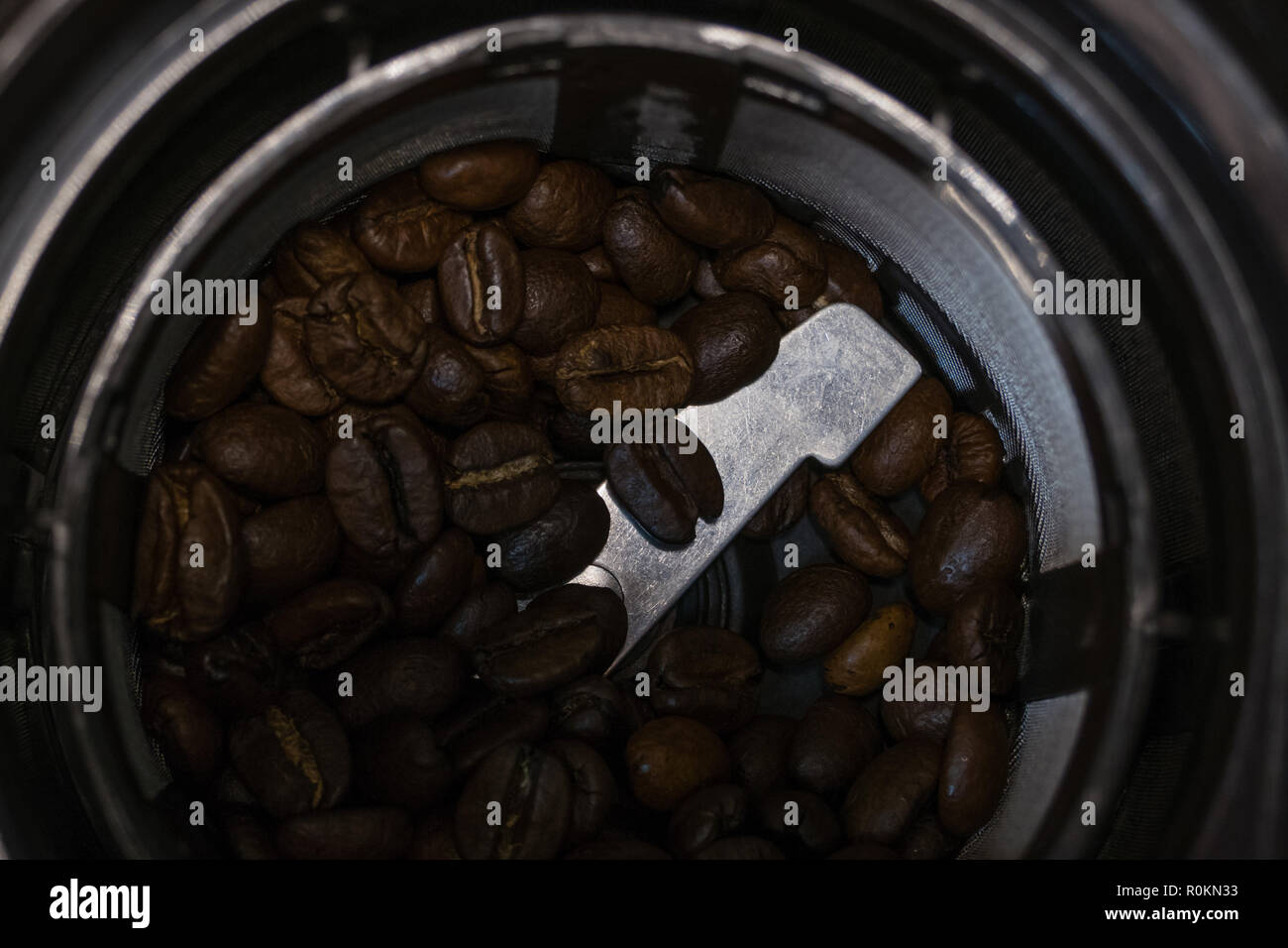 Coffee beans about to be ground in machine Stock Photo - Alamy