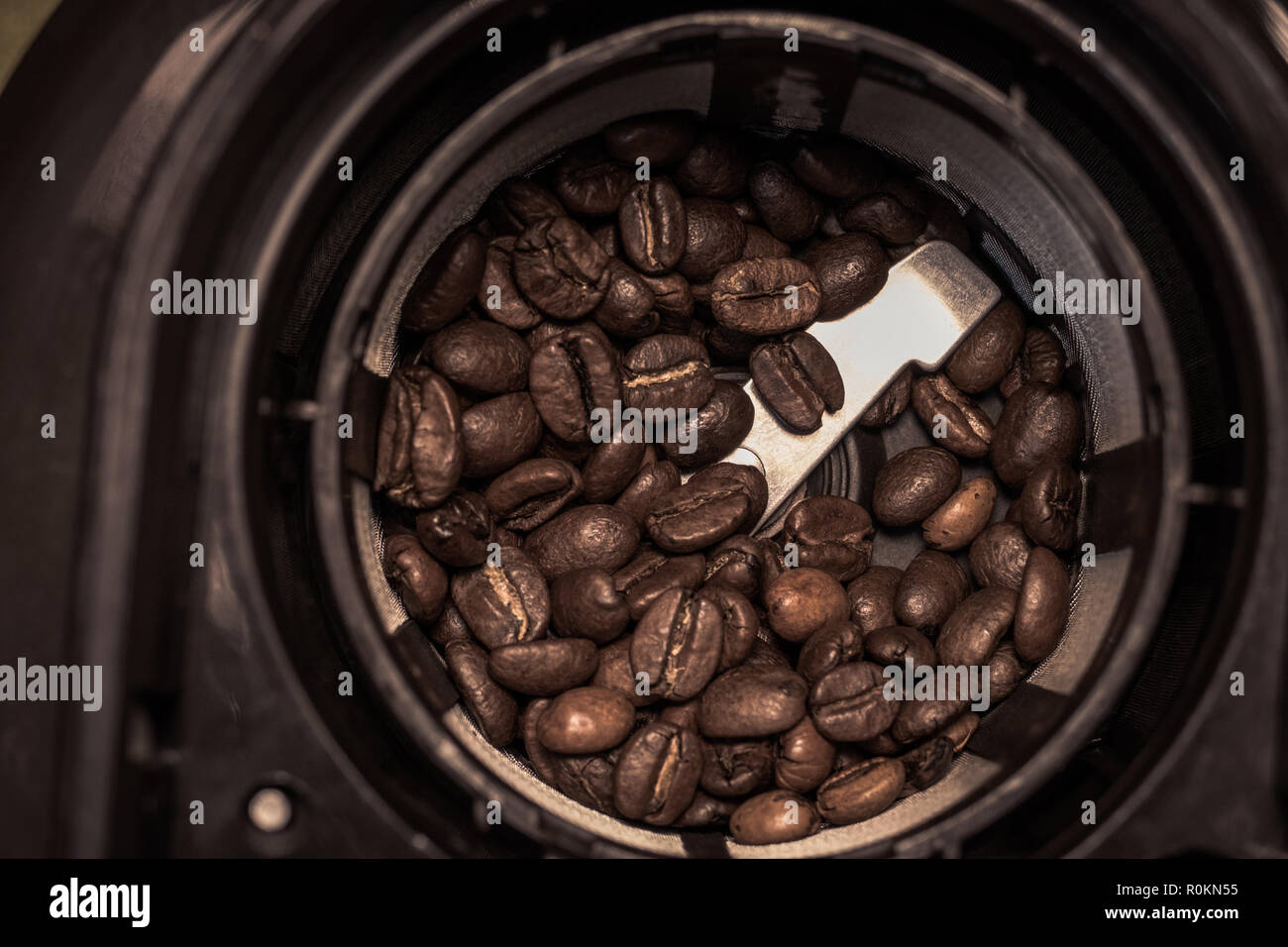 Coffee beans about to be ground in machine Stock Photo - Alamy