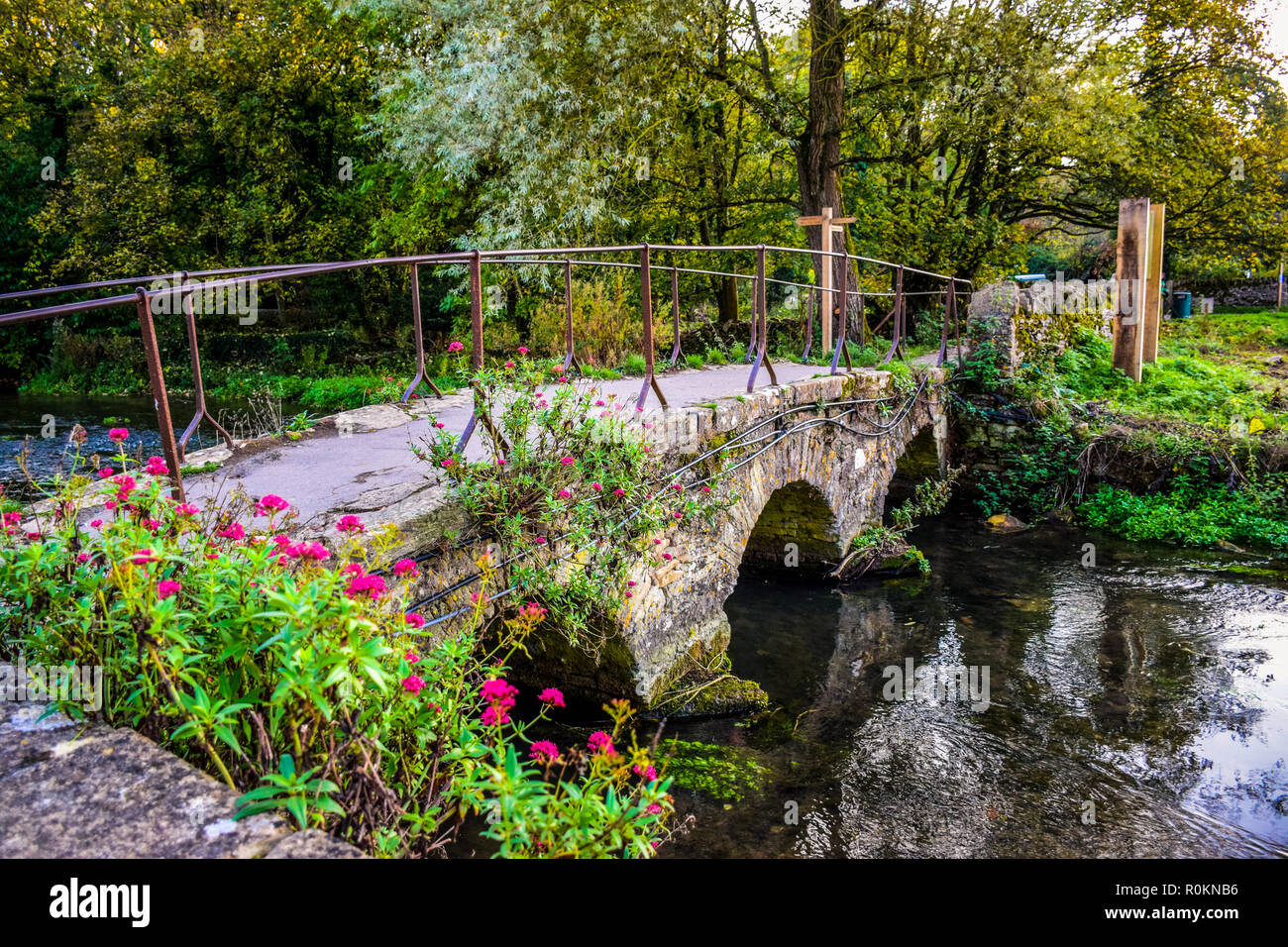 A small vintage stone bridge over river Coln that leads to Arlington ...