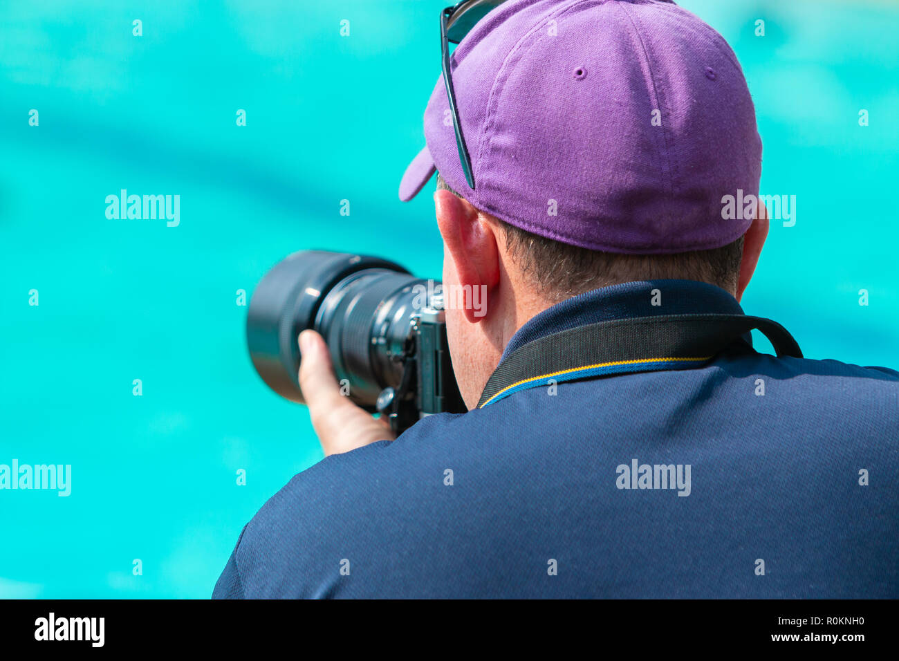Back view of a male photographer taking picture with his camera at a ...