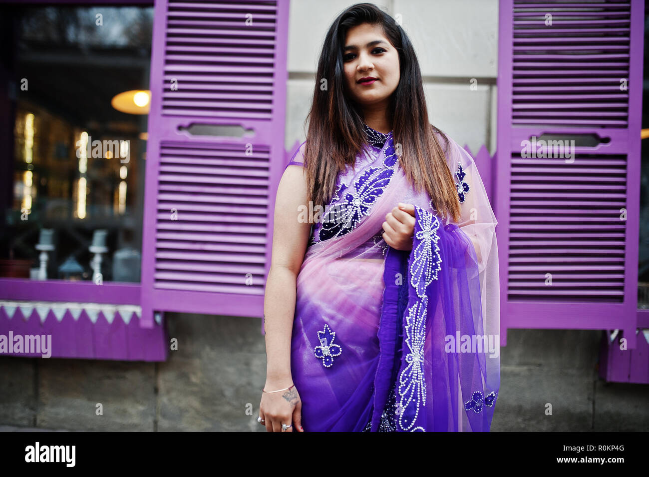 Indian hindu girl at traditional violet saree posed at street against ...