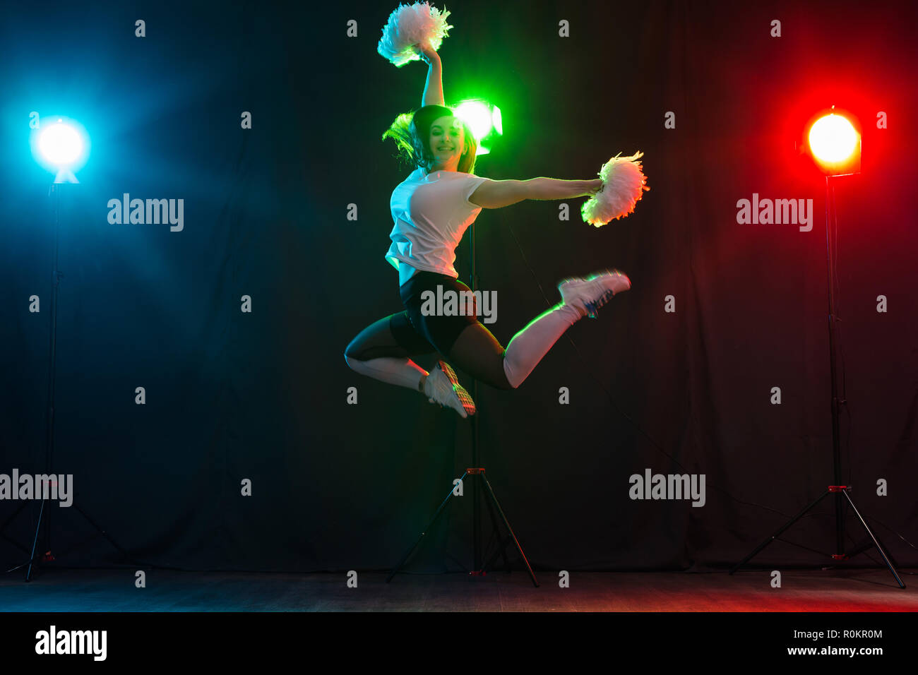 Full length portrait of cheerleader dancing with pom-poms Stock Photo ...