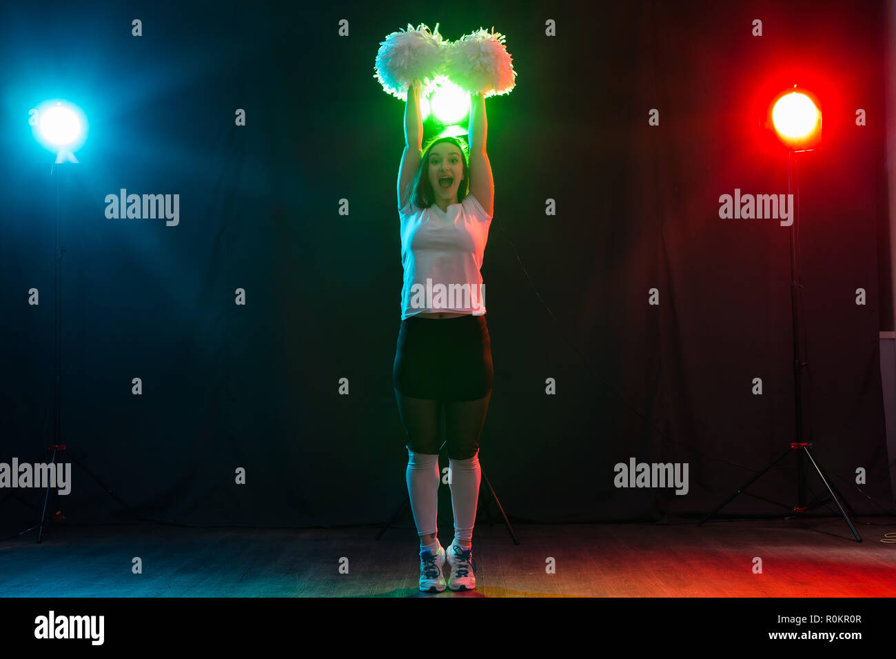 Full length portrait of cheerleader dancing with pom-poms Stock Photo ...