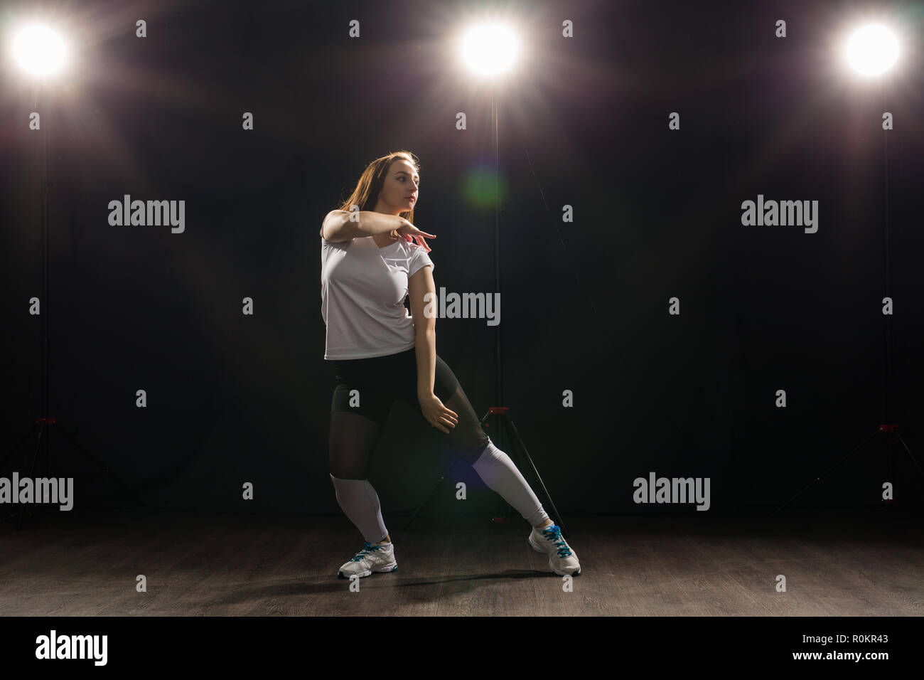 People and dance concept - Young woman dancing jazz funk over dark ...