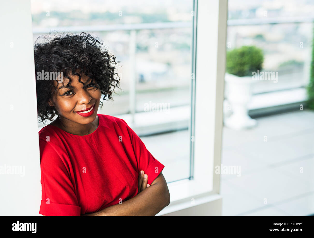 A portrait of woman standing by the window in an office Stock Photo - Alamy