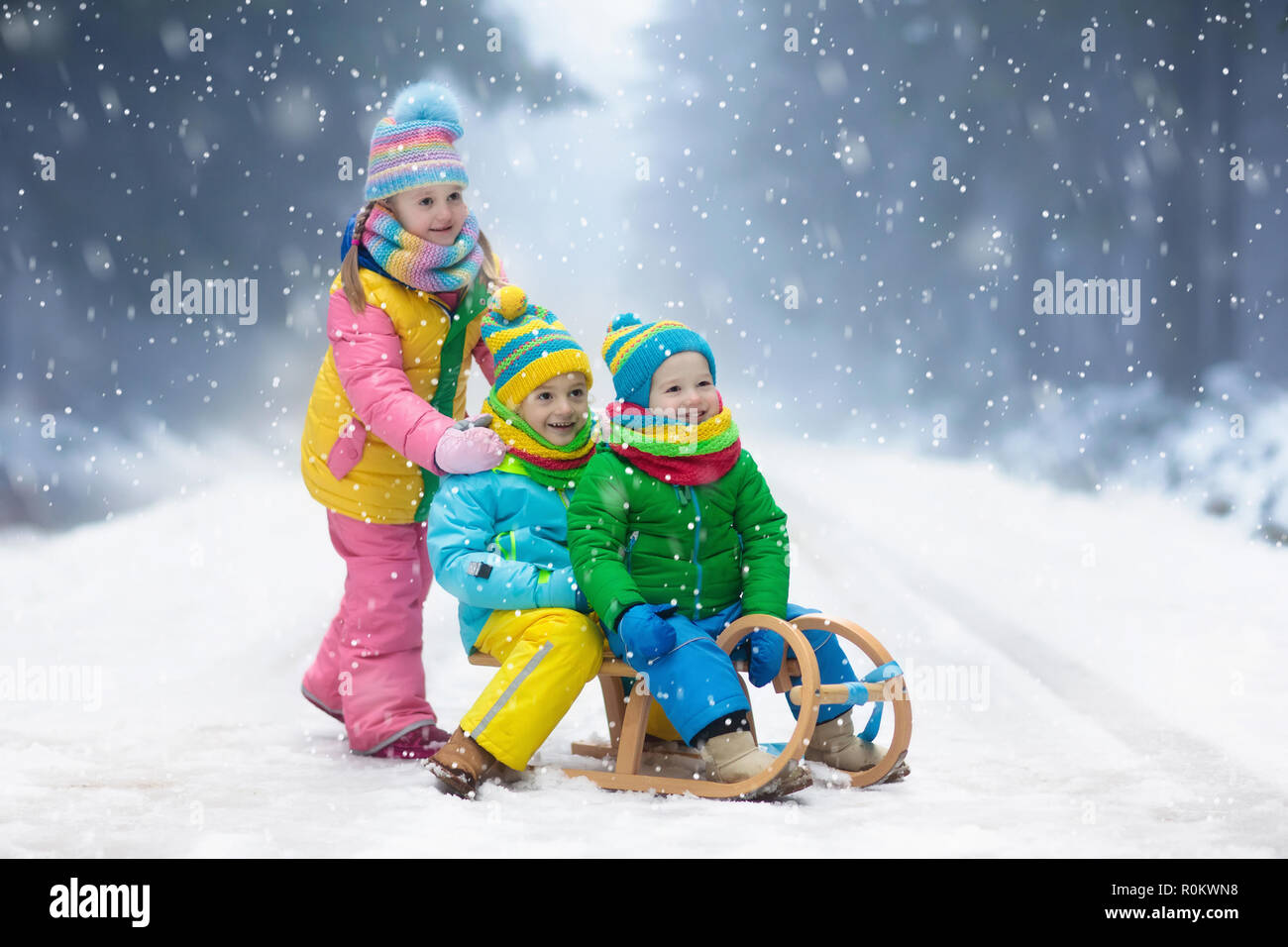 Little girl and boy enjoying sleigh ride. Child sledding. Toddler kid ...