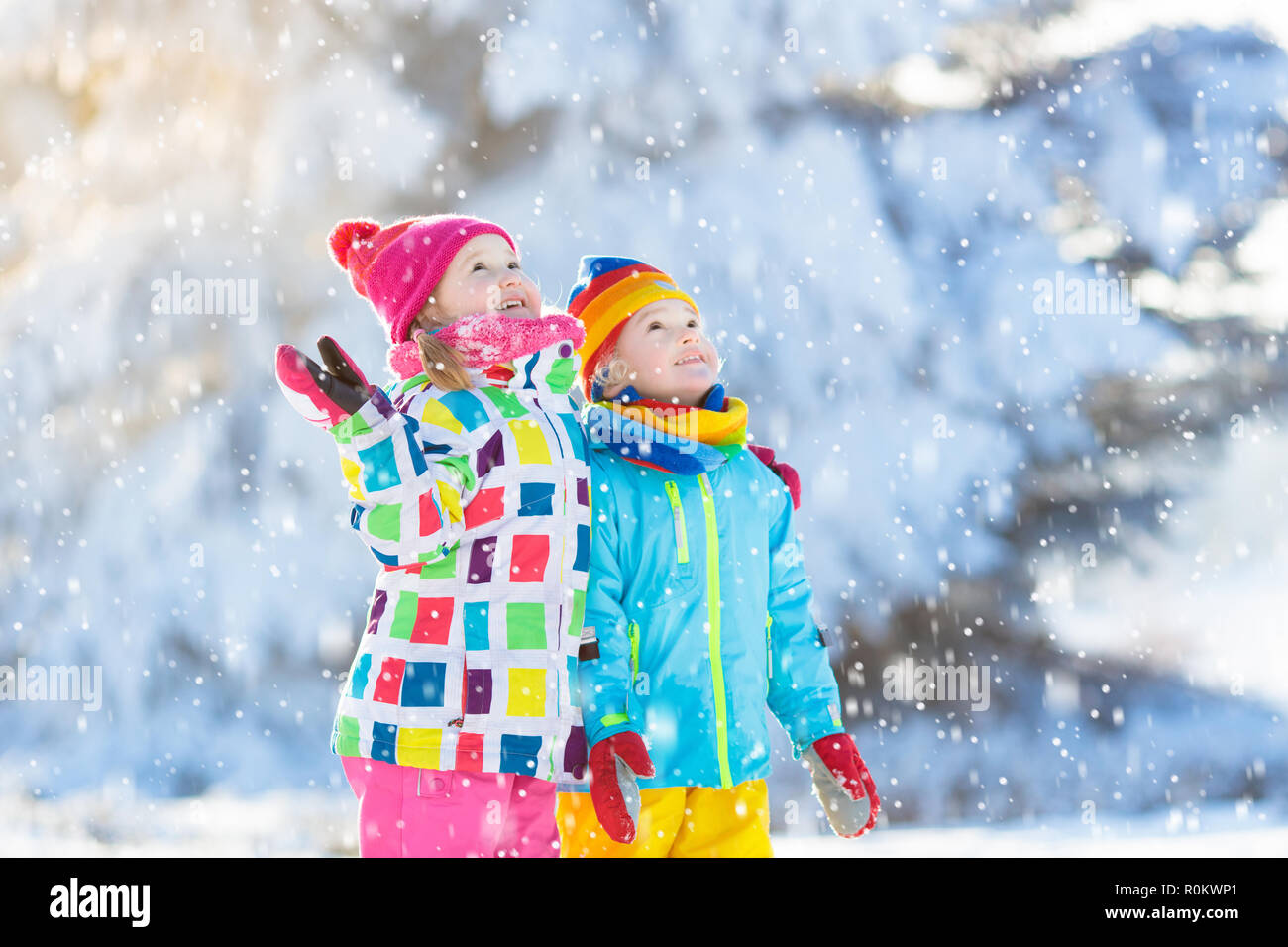 Kids playing in snow. Children play outdoors on snowy winter day. Boy ...
