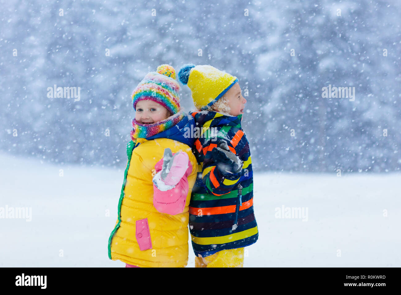 Kids playing in snow. Children play outdoors on snowy winter day. Boy ...