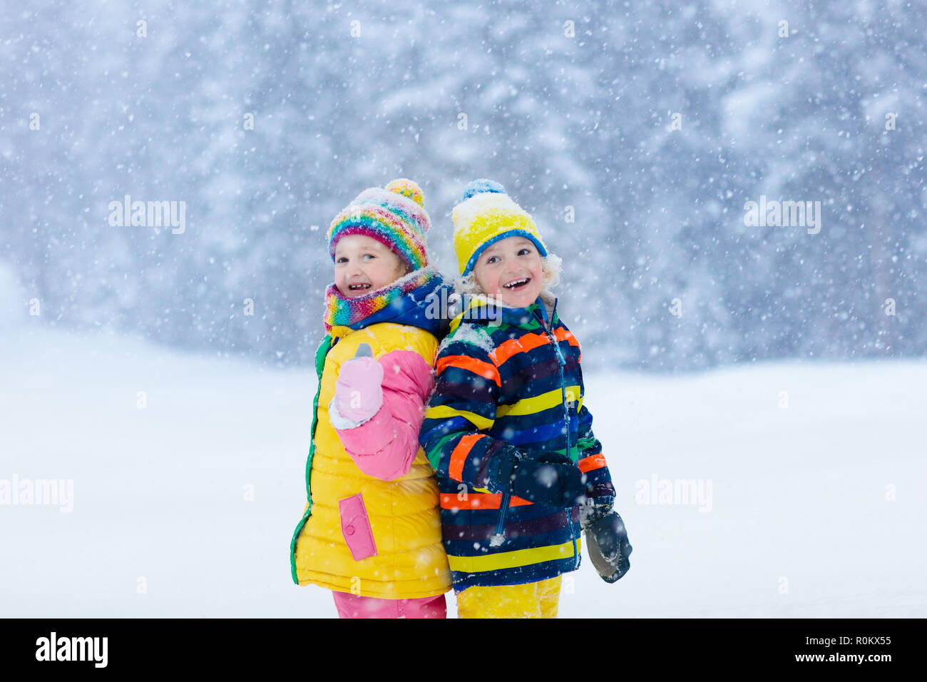 Kids playing in snow. Children play outdoors on snowy winter day. Boy ...