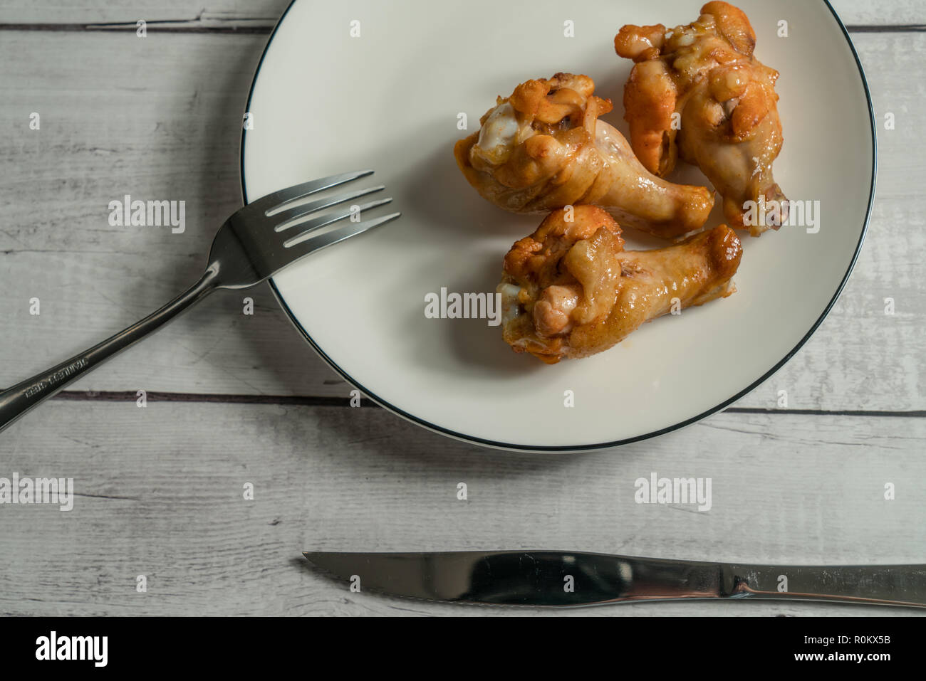 Roast chicken wring on the wooden table Stock Photo - Alamy