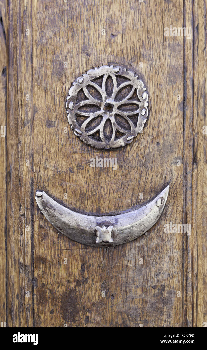 Old metal peephole, detail of an old wooden door with metal decoration ...
