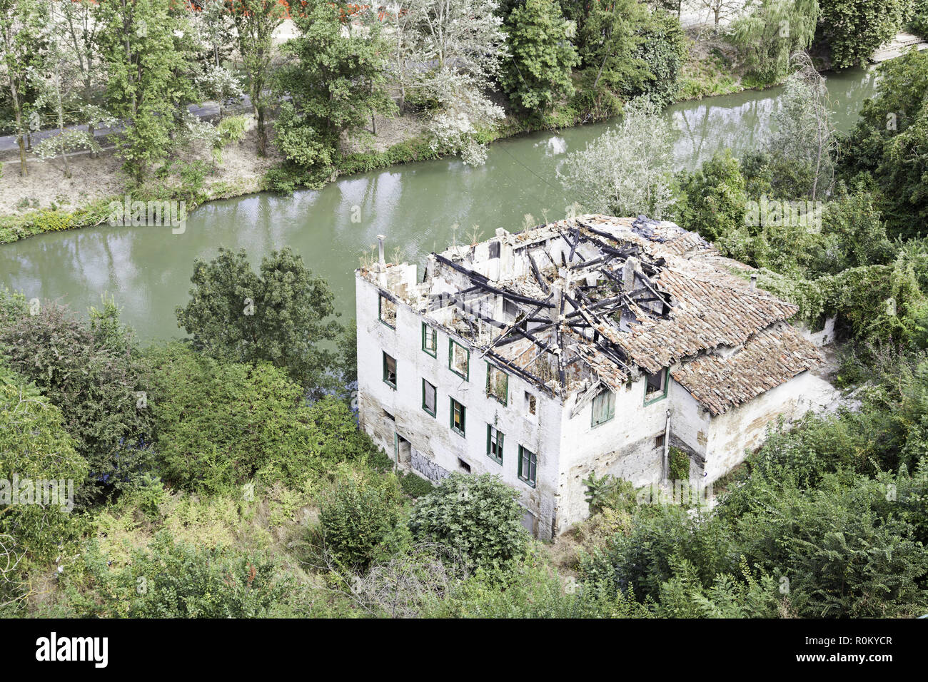 Old house in ruins, detail of a ruined house next to a river, neglect ...
