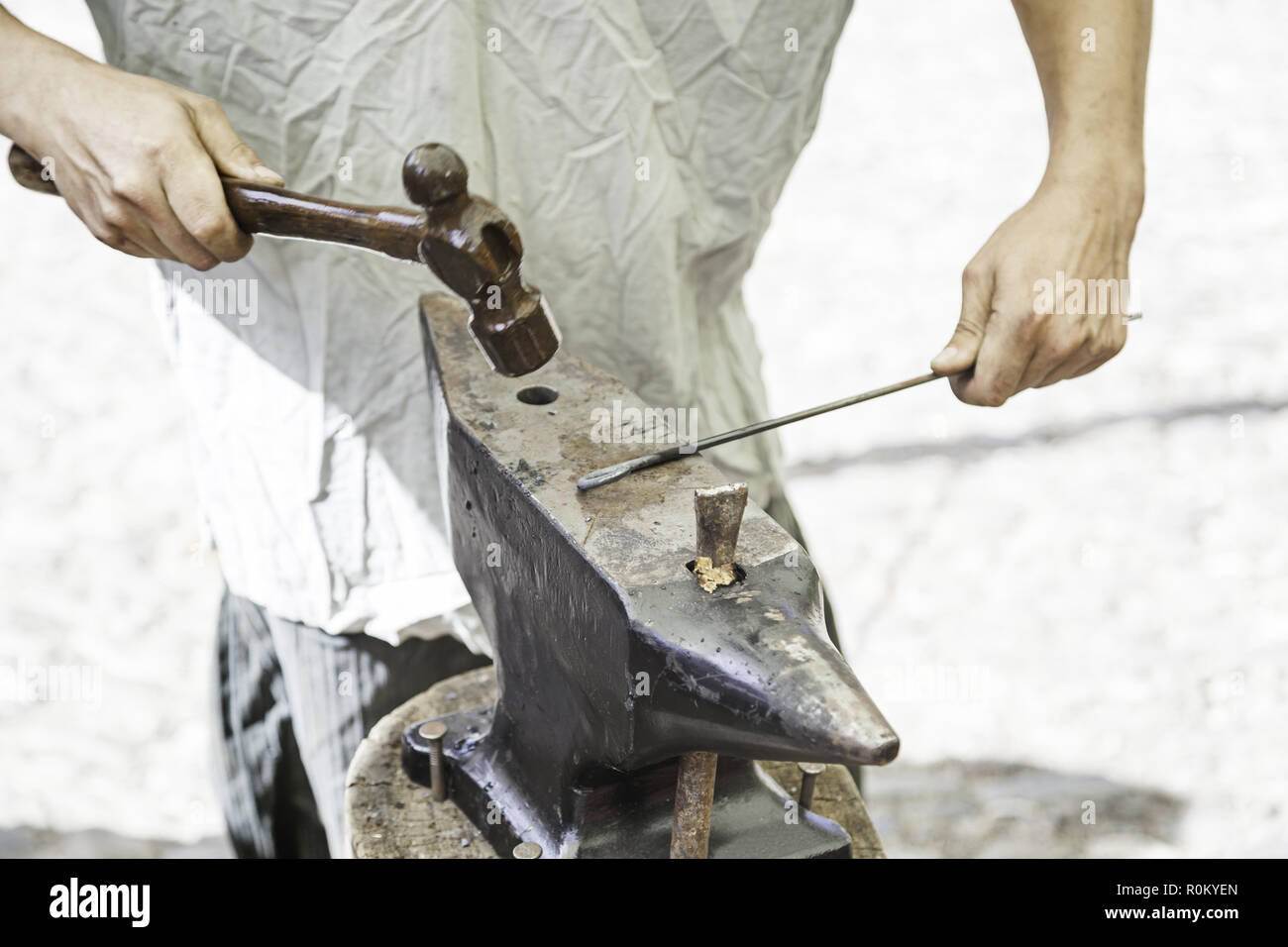 Blacksmith working iron, hitting a worker detail and shaping iron ...