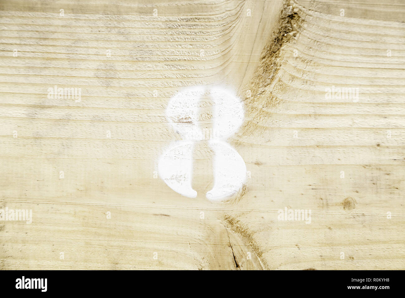 Number eight on wood, detail of a figure painted on a wooden wall ...