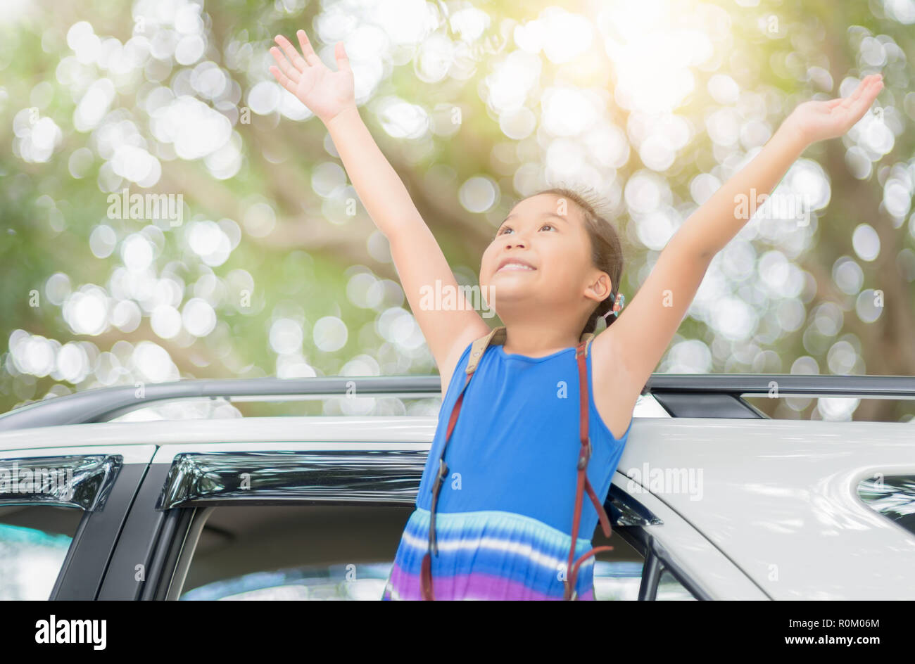 Happy kid with raised arms from window car against forest. Freedom and ...