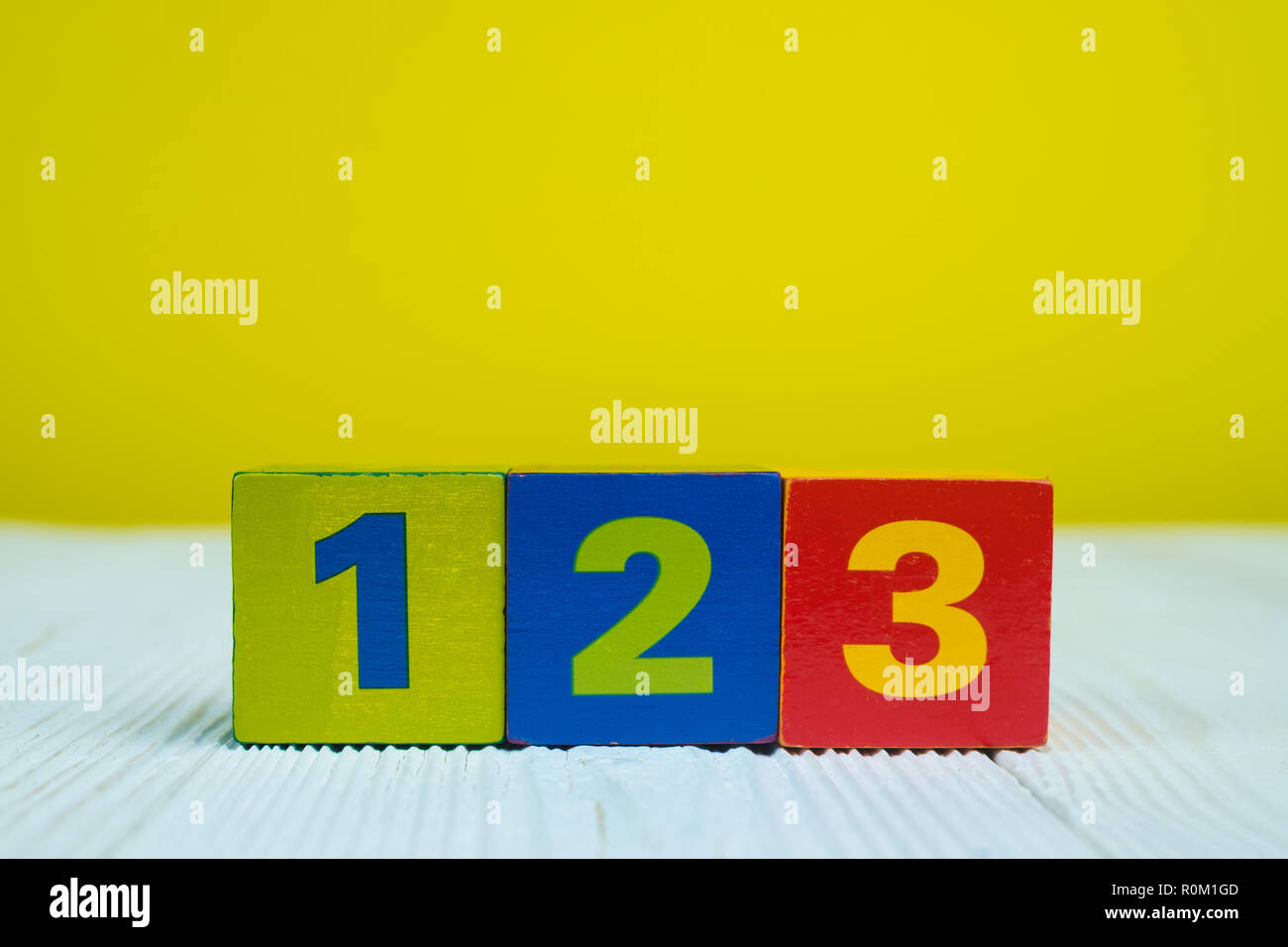 Square block puzzle number 1 2 and 3 on table with yellow wall ...