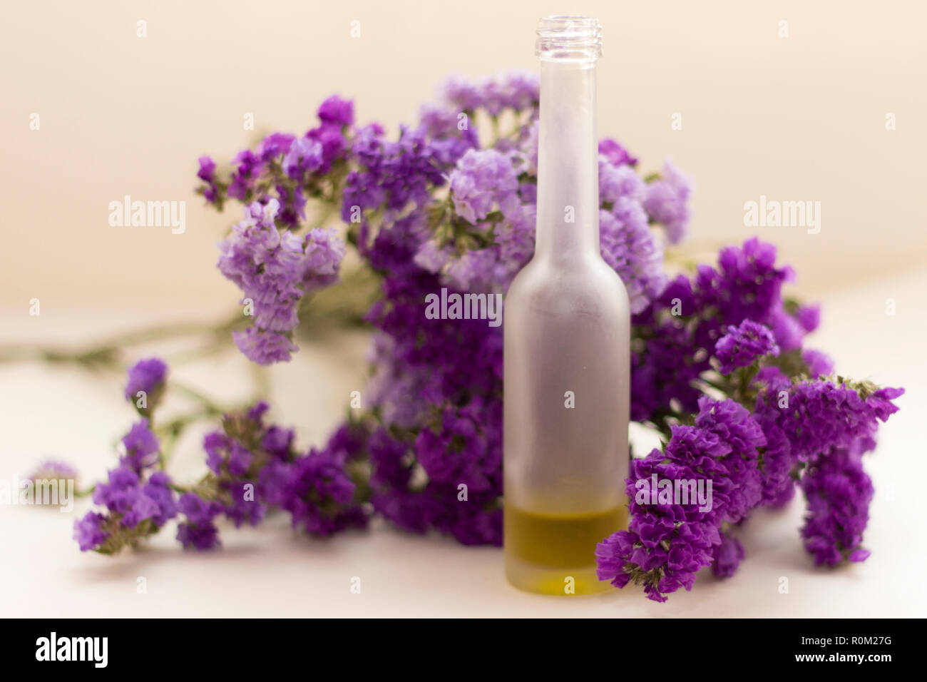 Essential oil in matt bottle on purple flowers blur background Stock ...