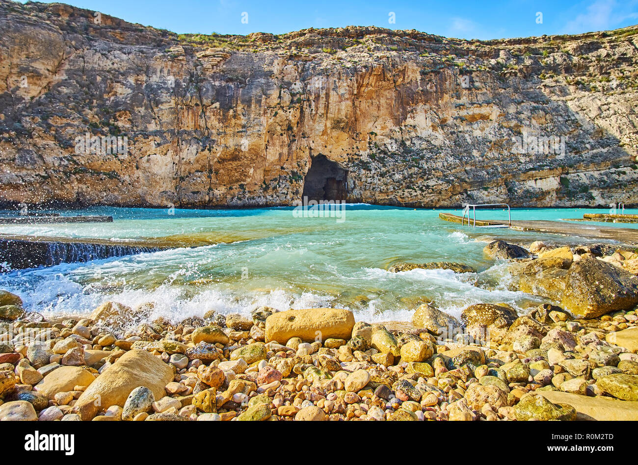 The Dwejra Inland Sea with tall cliffs, rocky shores, tiny beach and ...