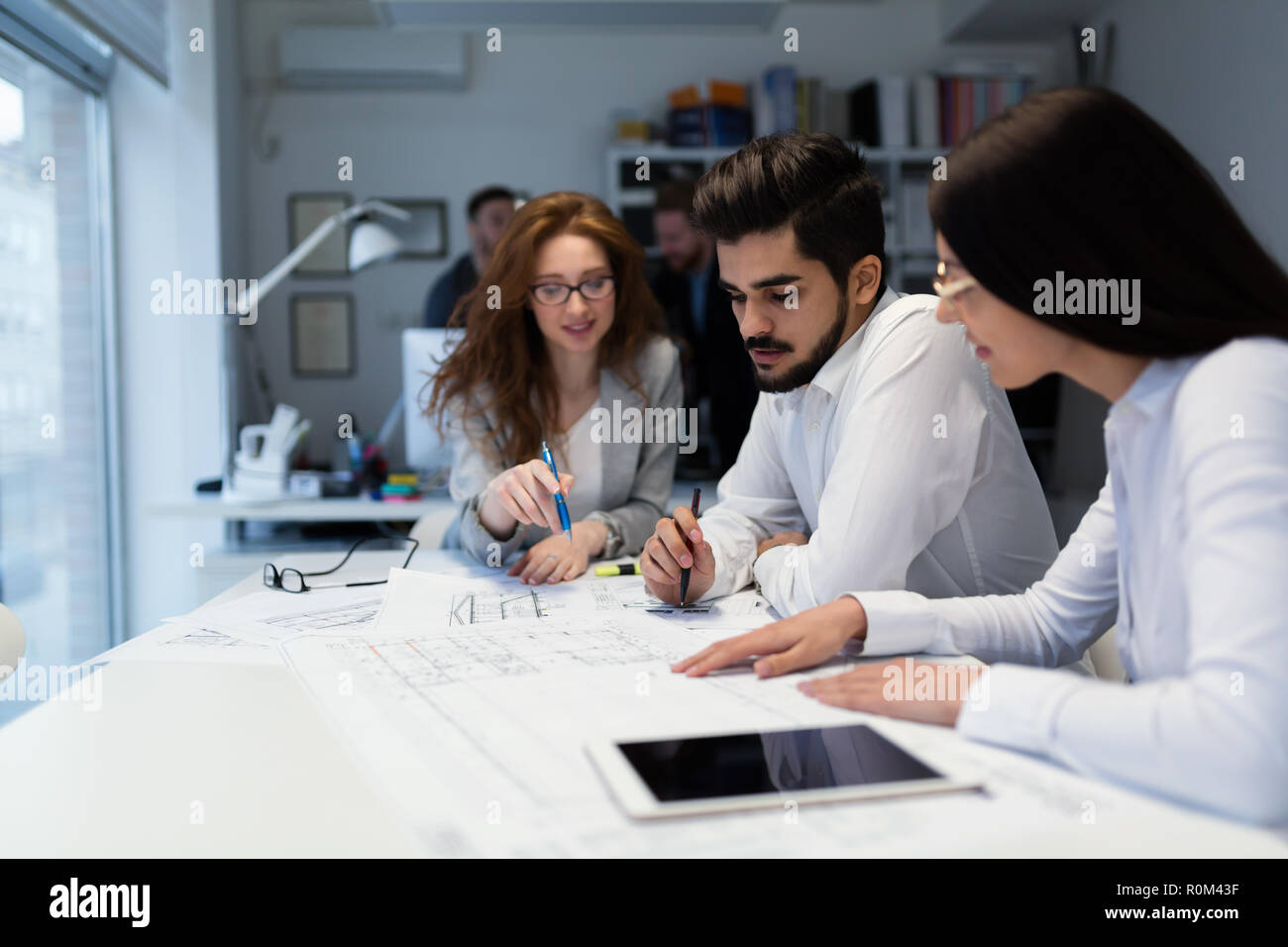 Group of architects working together on project Stock Photo - Alamy