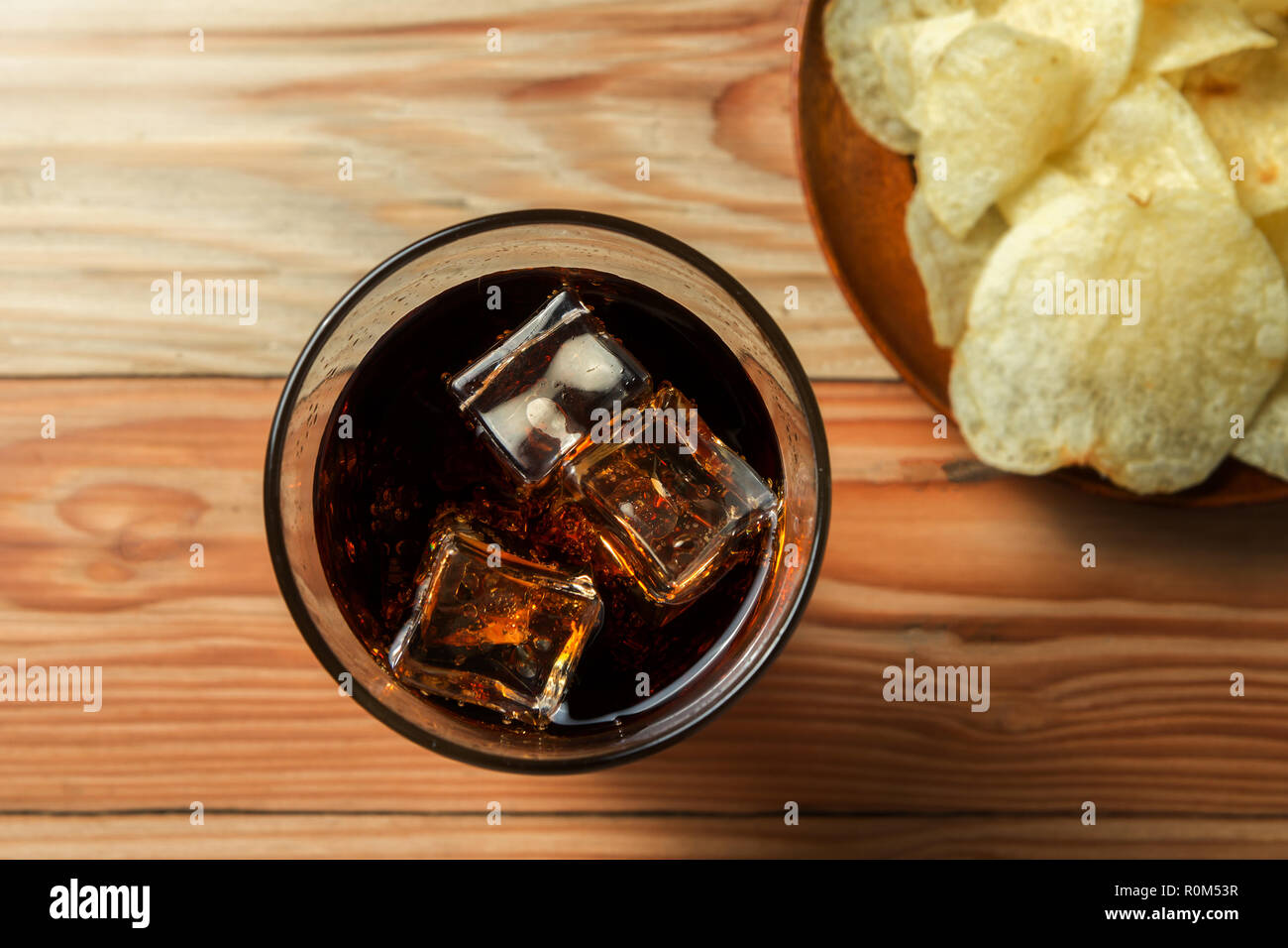 Potato chips with cola on a wooden background Stock Photo - Alamy