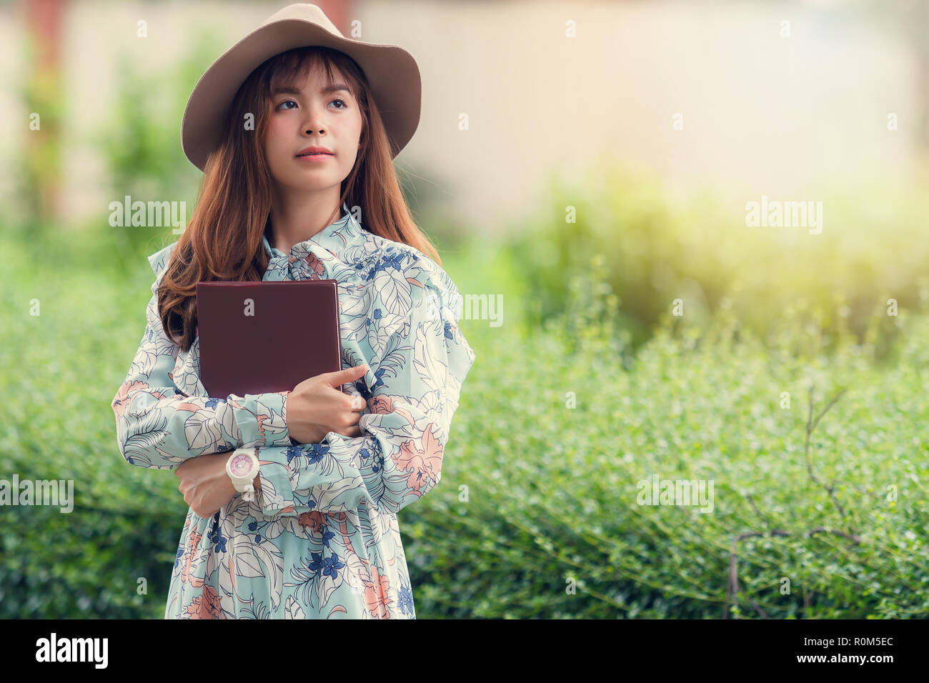Young asian woman in retro style with a book strolling in park Stock ...
