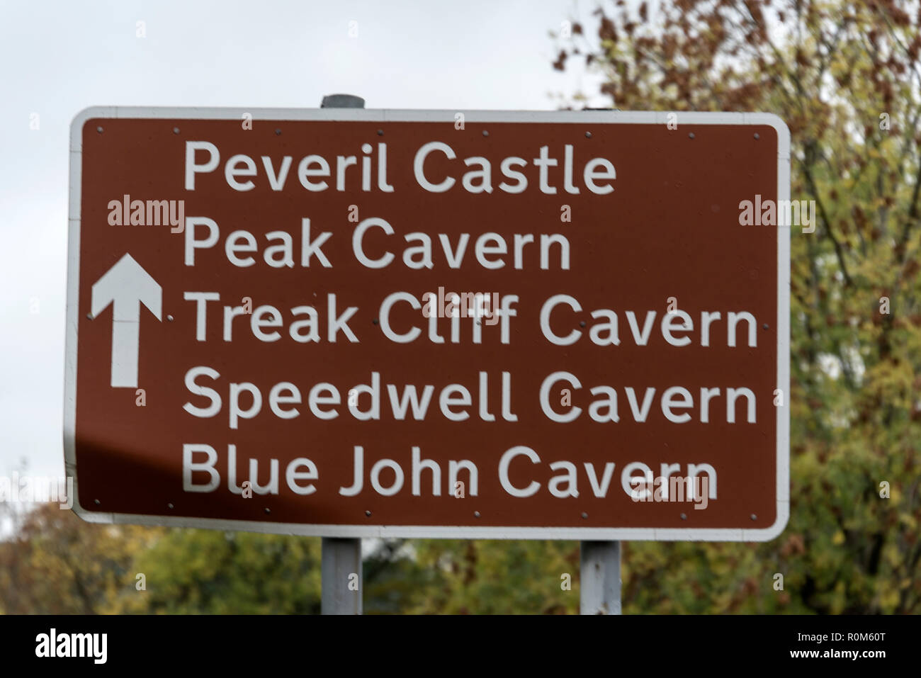 A tourist road sign of a list of four caverns and a castle ruin at ...