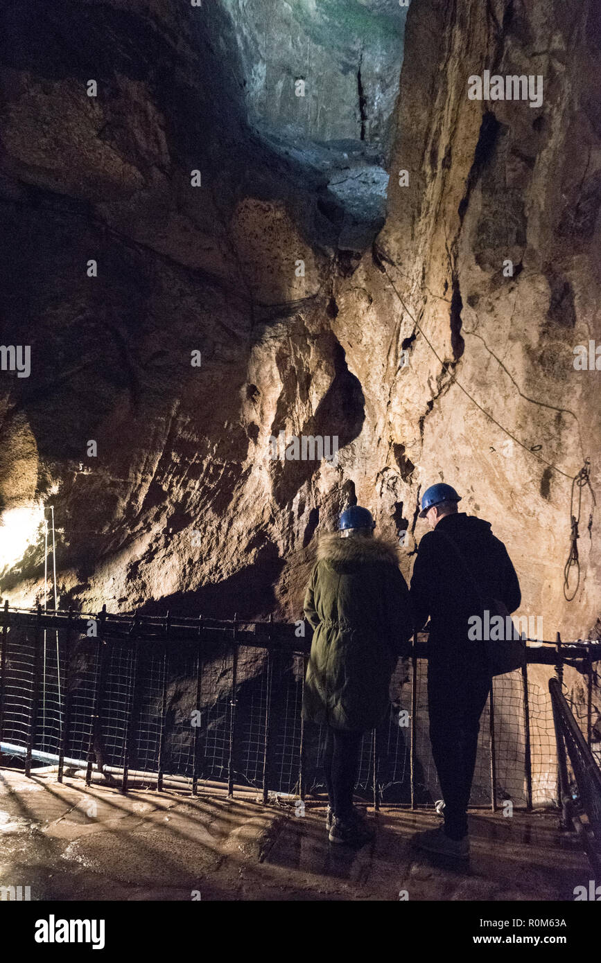 A couple of visitors wearing safety helmets, peer down a 20 metres ...
