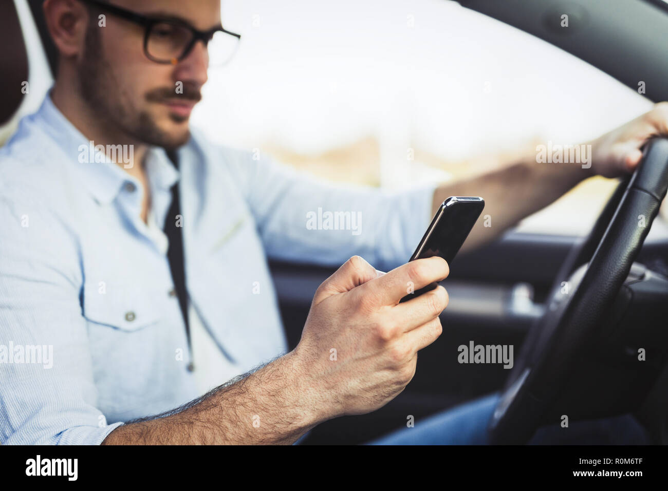 Man driver using smart phone in car modern Stock Photo - Alamy