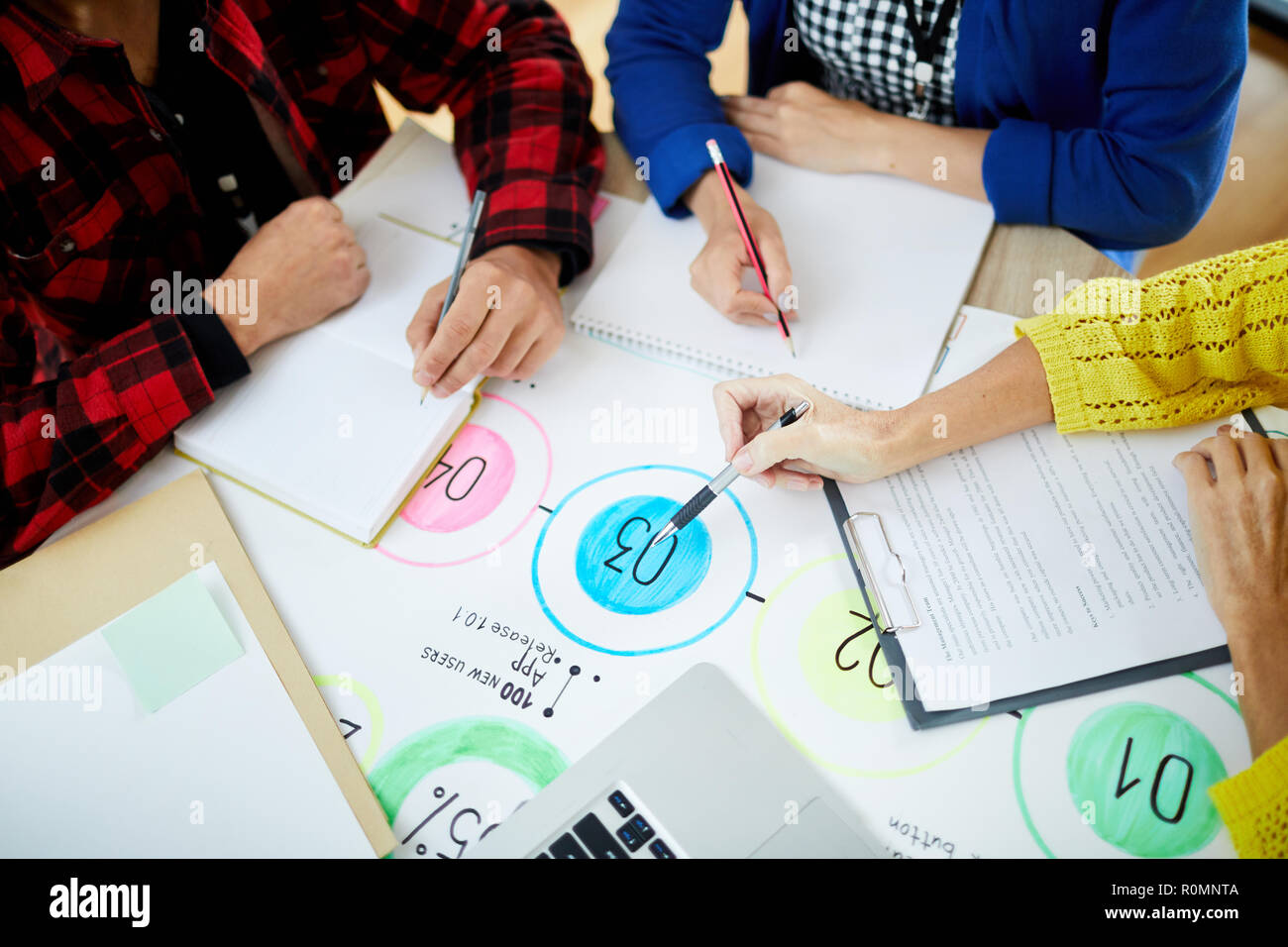 Hands of colleagues during discussion of development scheme while ...