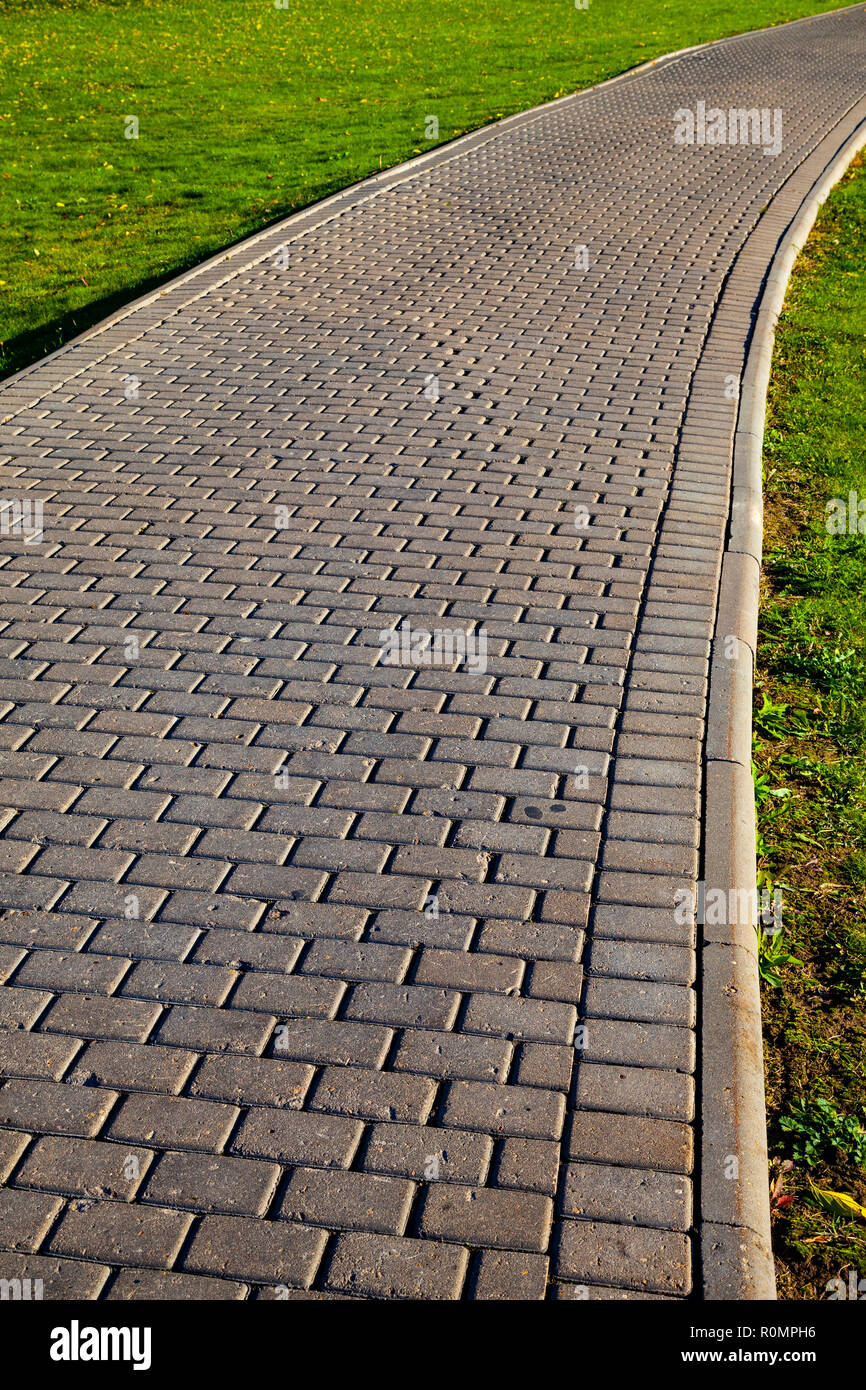 Stone path in the park and green lawn. Beautiful summer city park for ...