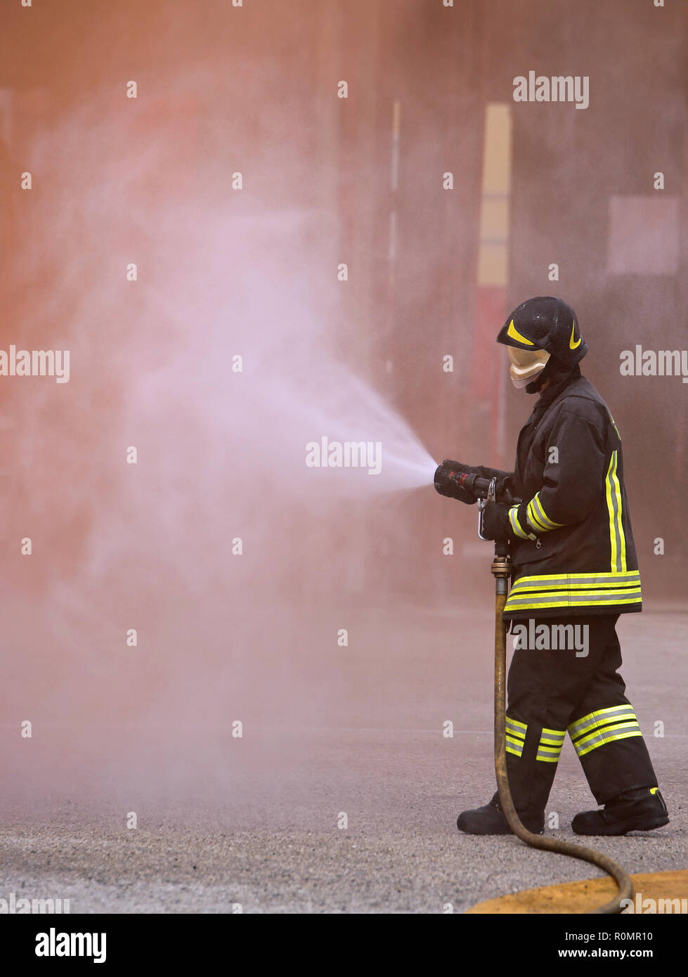 firefighter uses a powerful fire extinguisher to extinguish a fire ...