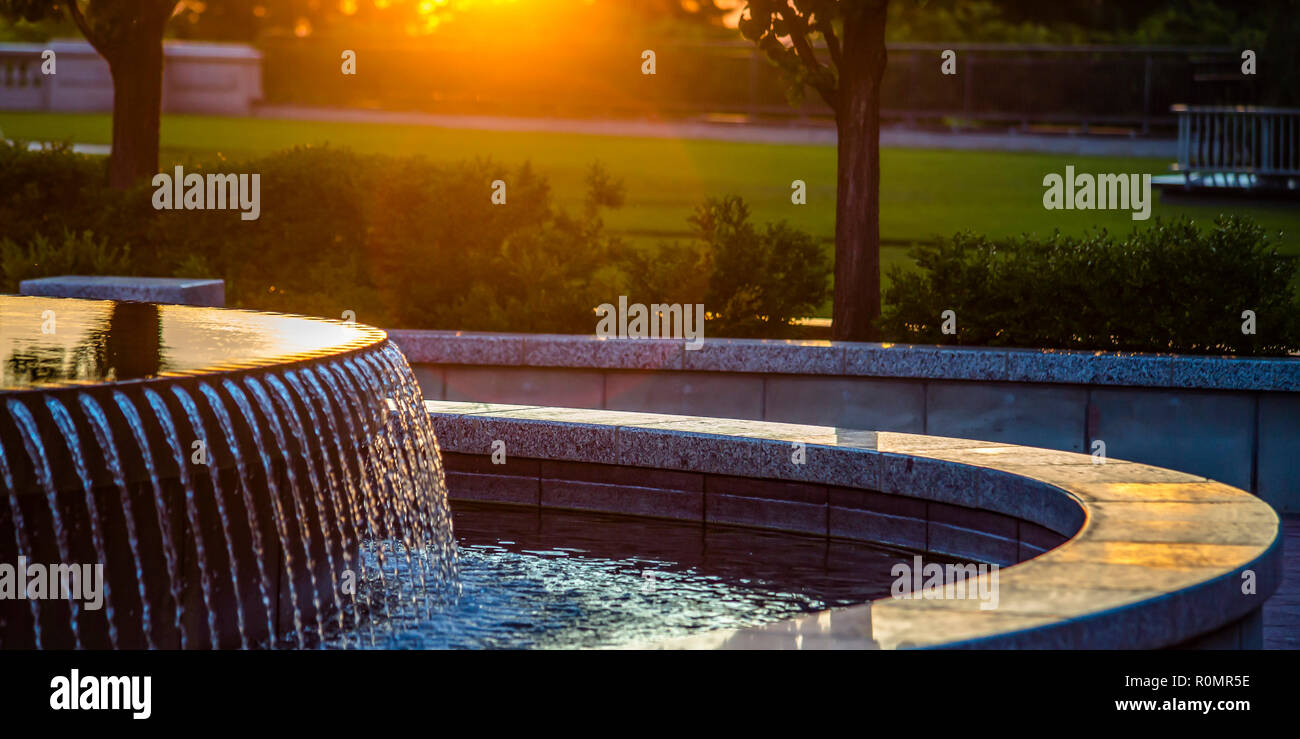 Outdoor fountain with reflective water at sunset Stock Photo - Alamy