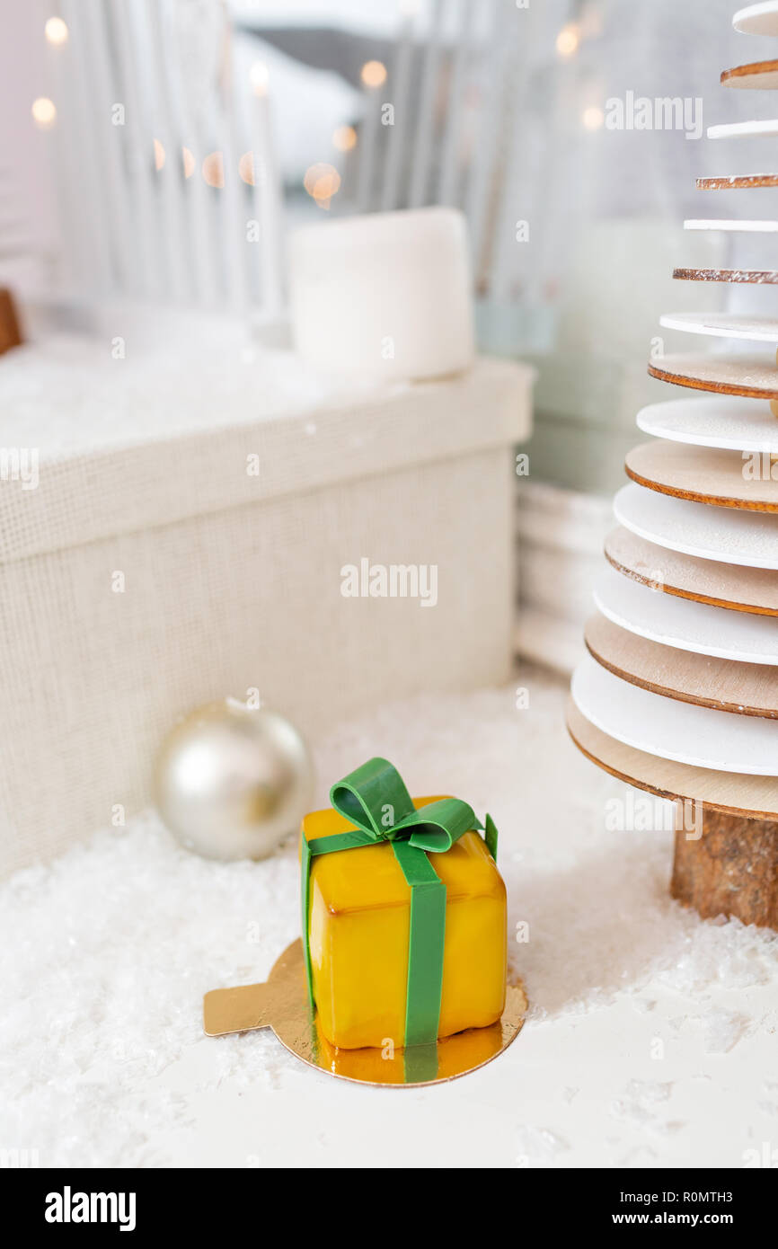 Mini mousse pastry dessert with yellow glazed. In the form of gift box ...