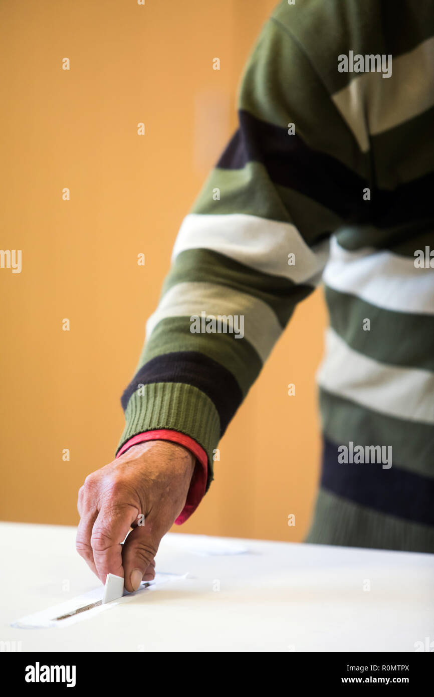 Color image of a person casting a ballot at a polling station, during ...