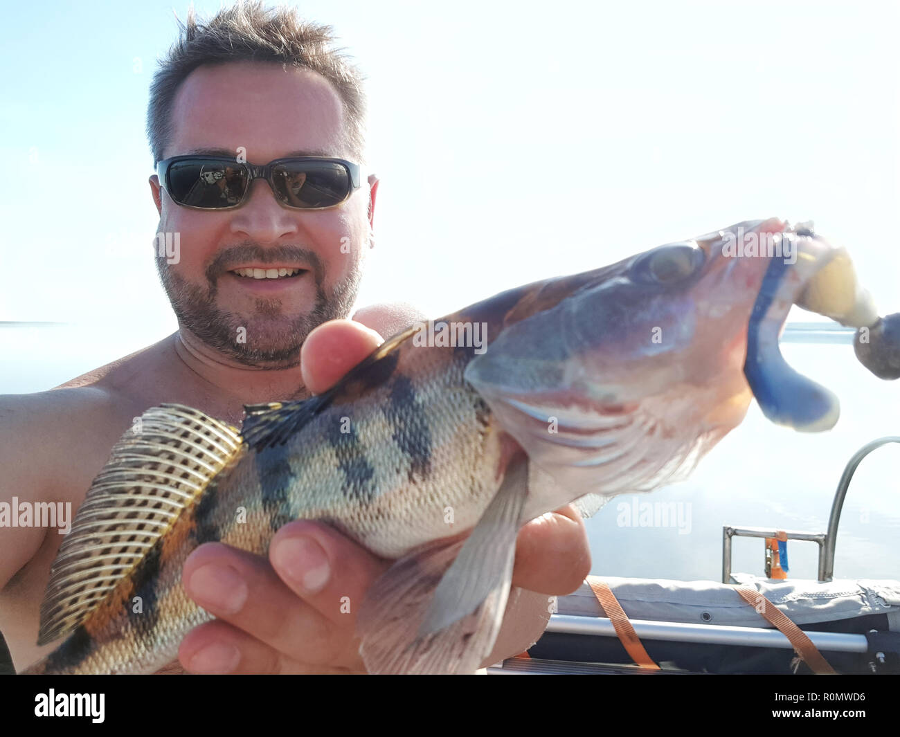 Happy man with a fish on a fishing trip Stock Photo - Alamy