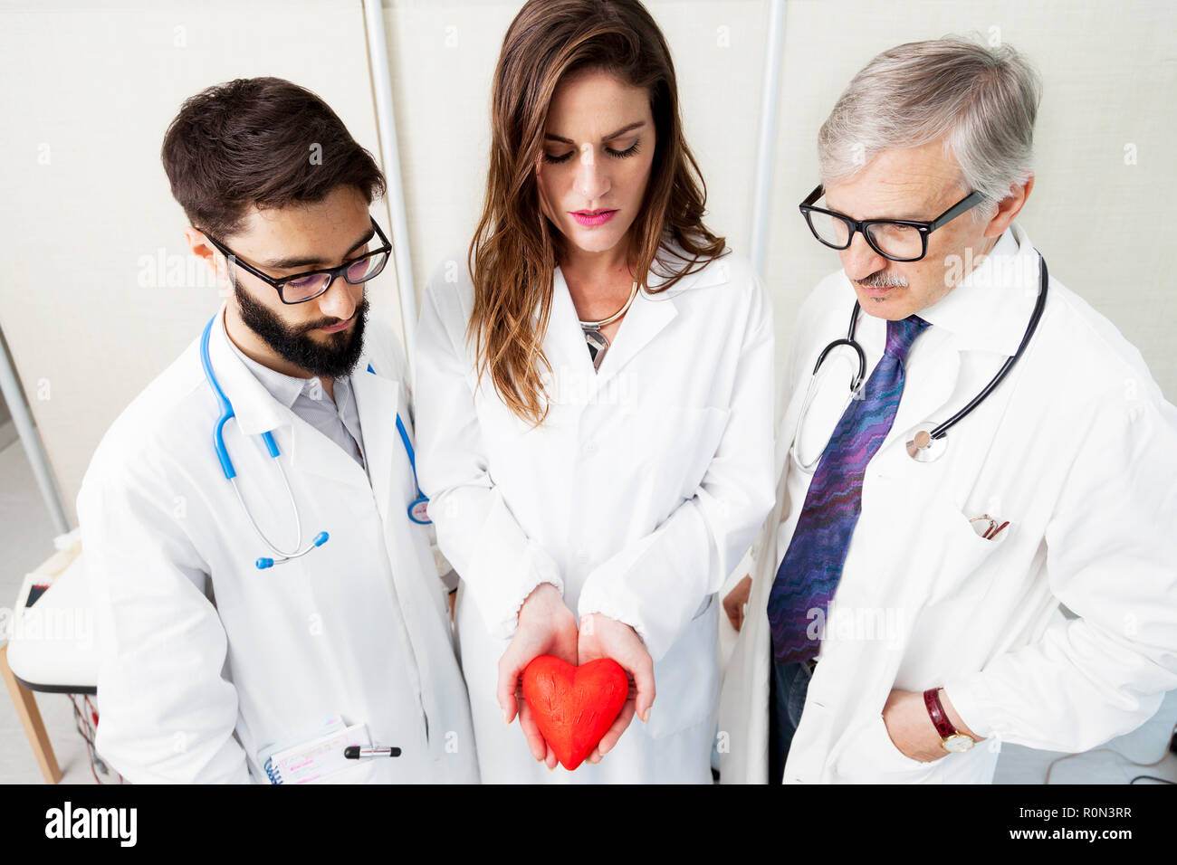 group of doctors with a symbol heart in their hands Stock Photo - Alamy