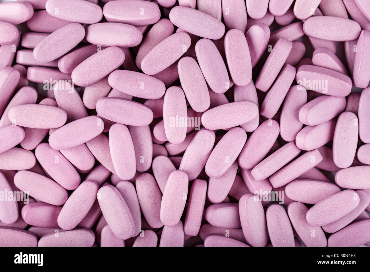 long pink pills as a background. treatment of diseases by medicines ...