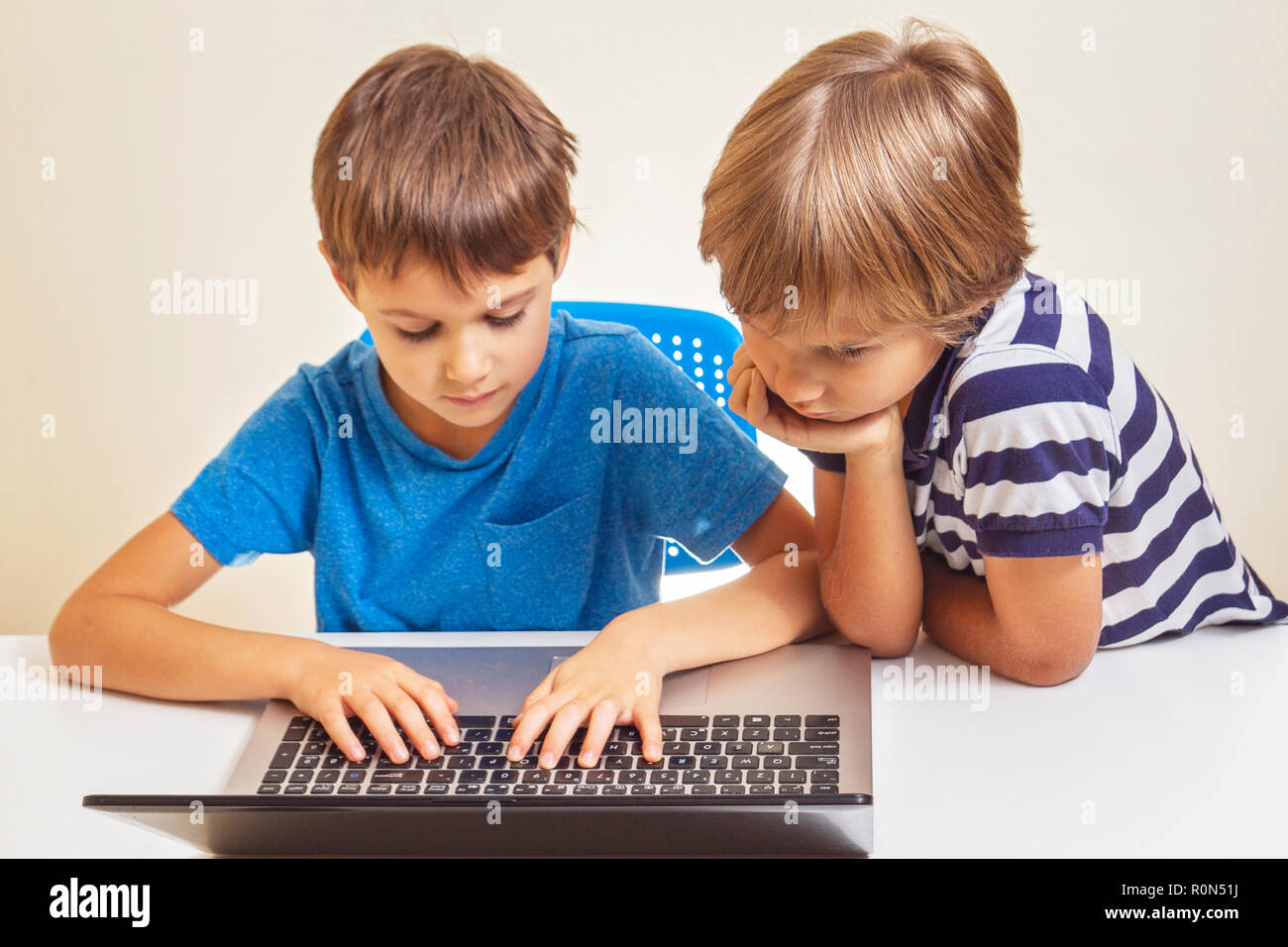 Two kids with laptop computer Stock Photo - Alamy