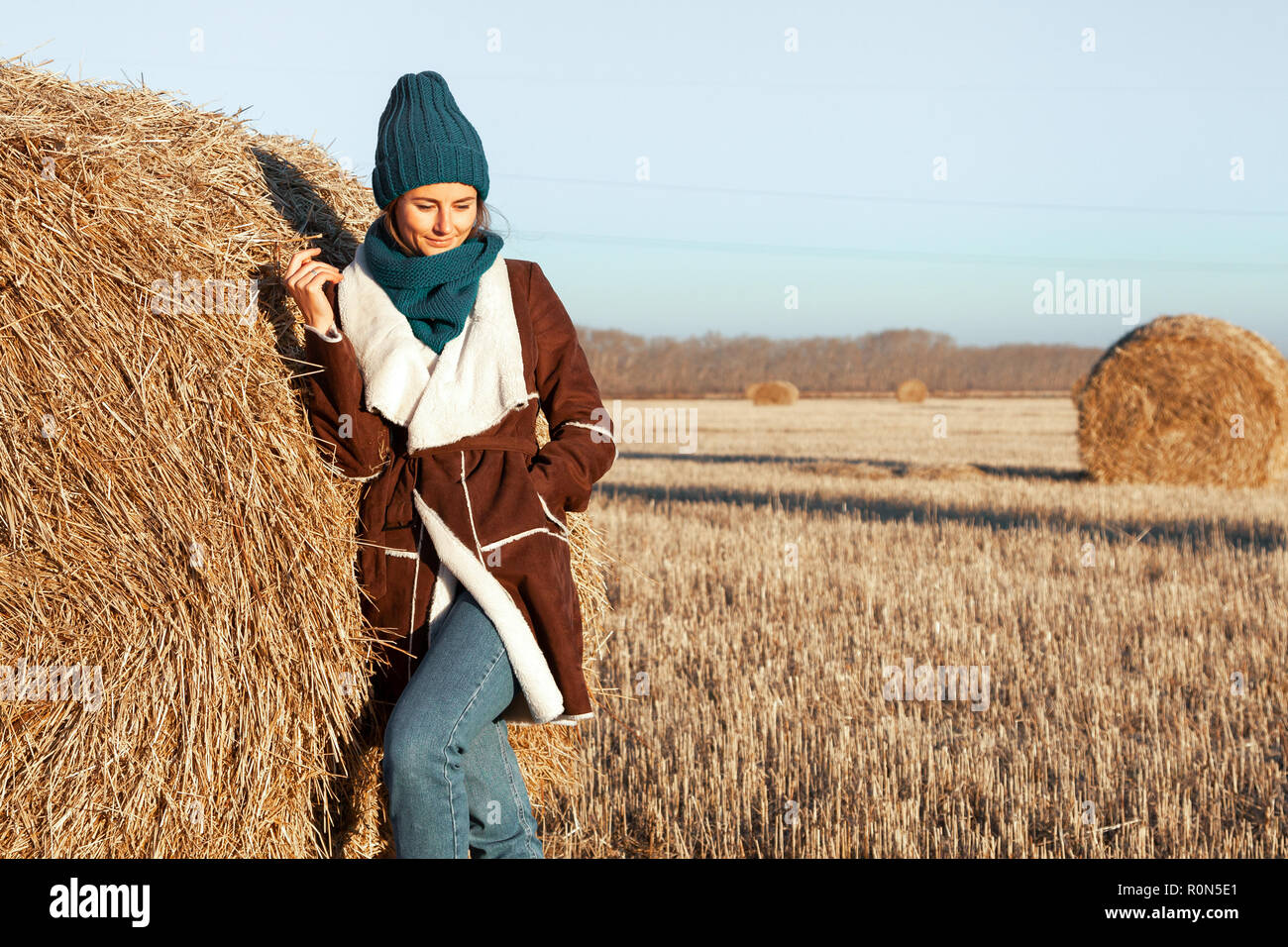 Young attractive lady in blue knitting hat and brown coat stay under ...