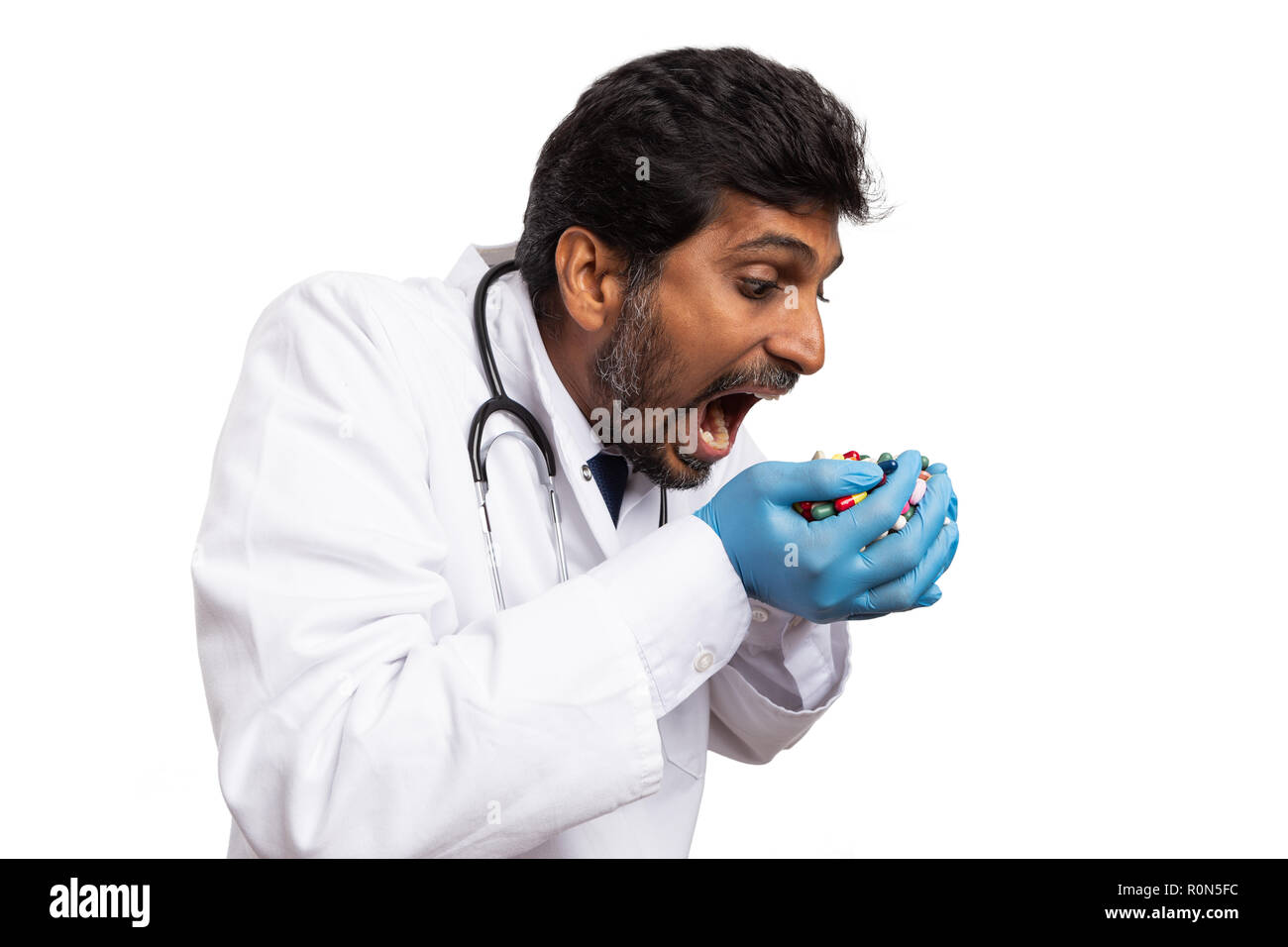 Addicted indian male medic taking handful of medicine isolated on white ...