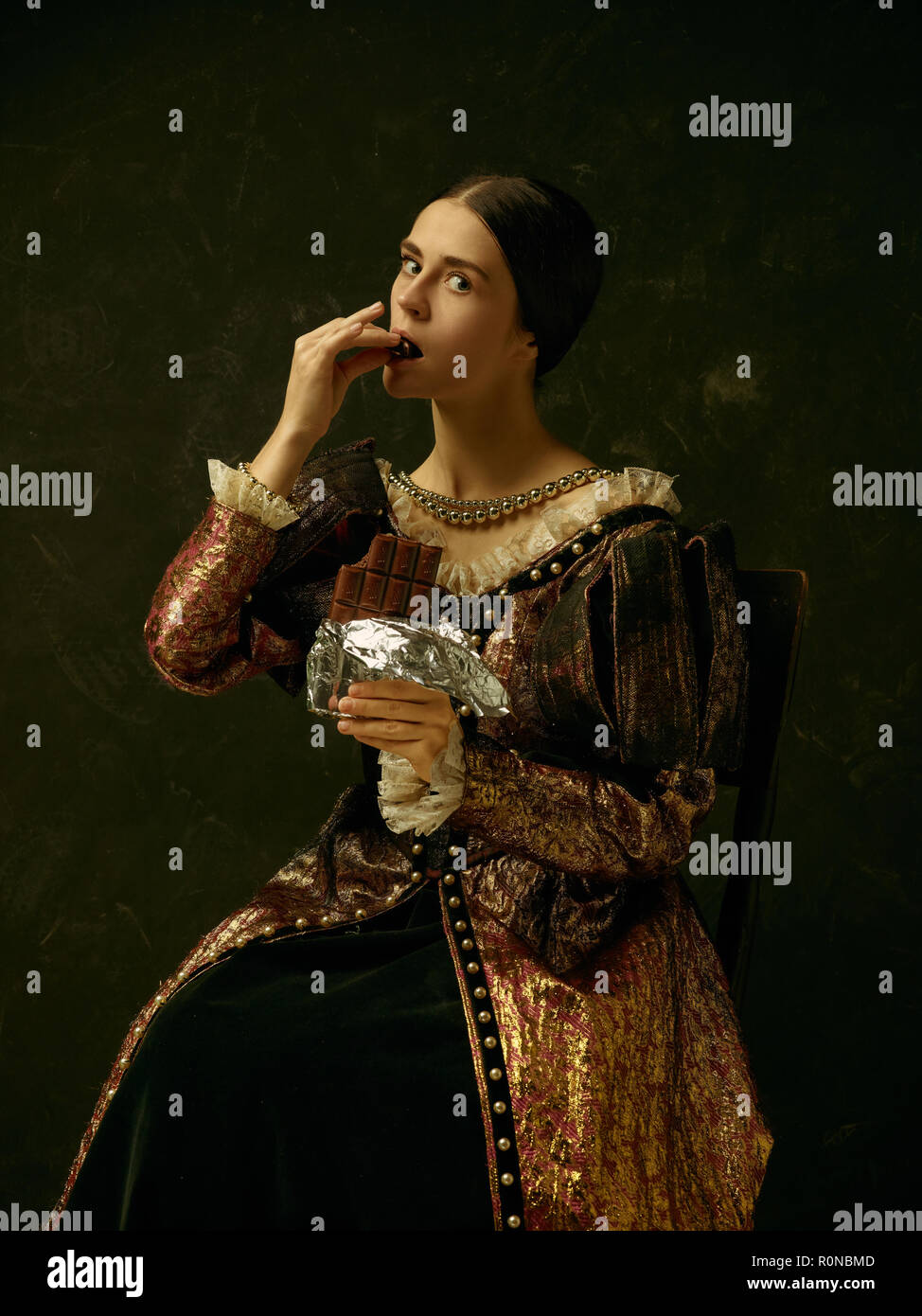 Portrait of a girl wearing a princess or countess dress over dark ...