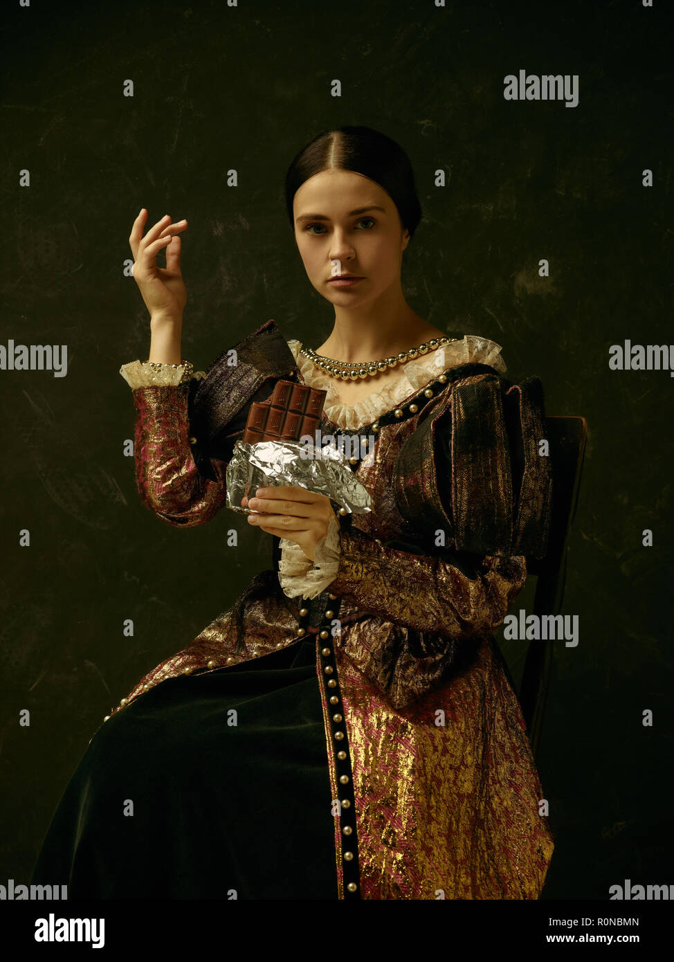 Portrait of a girl wearing a princess or countess dress over dark ...