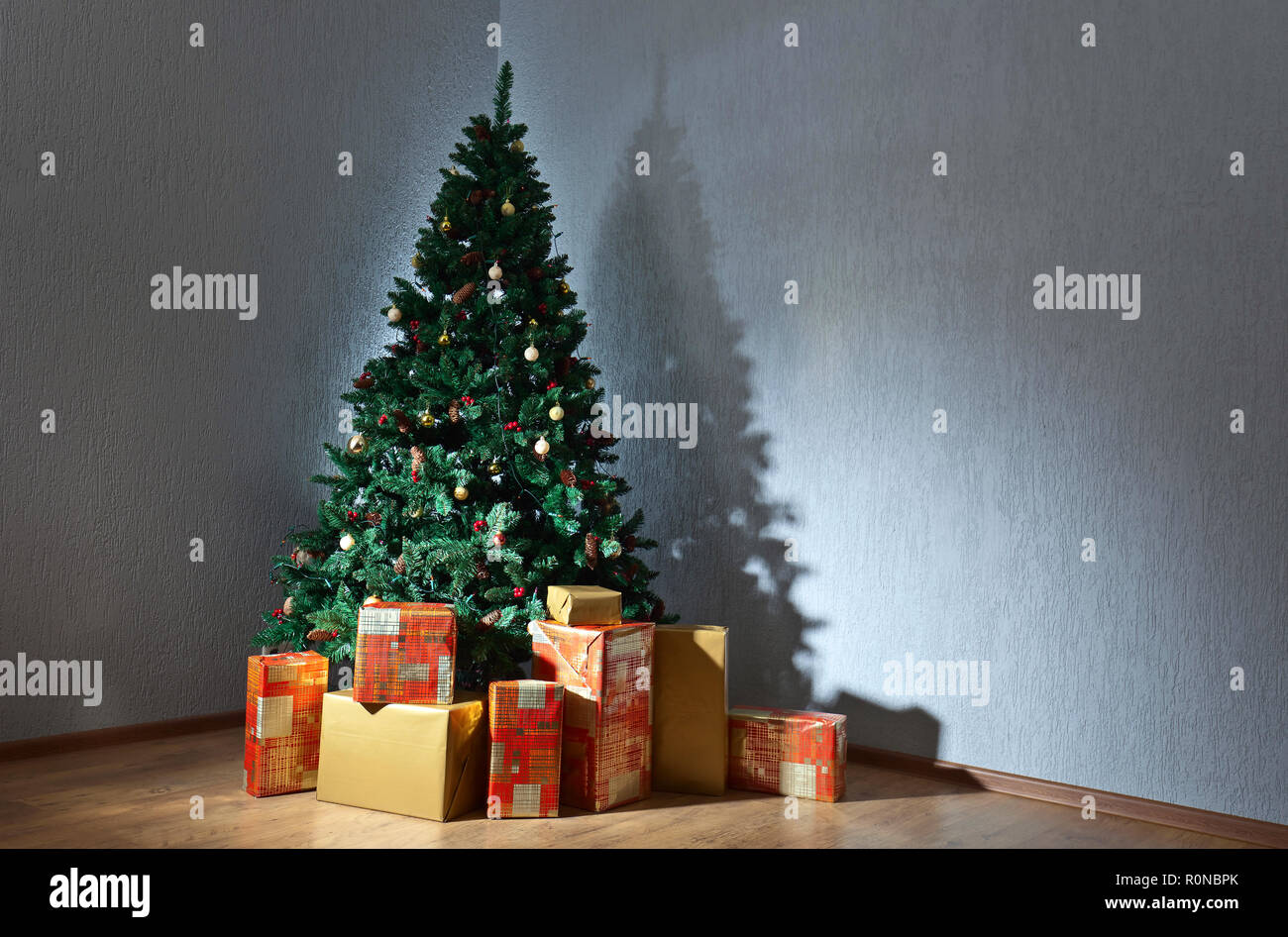 Christmas tree with gifts in an empty room Stock Photo - Alamy