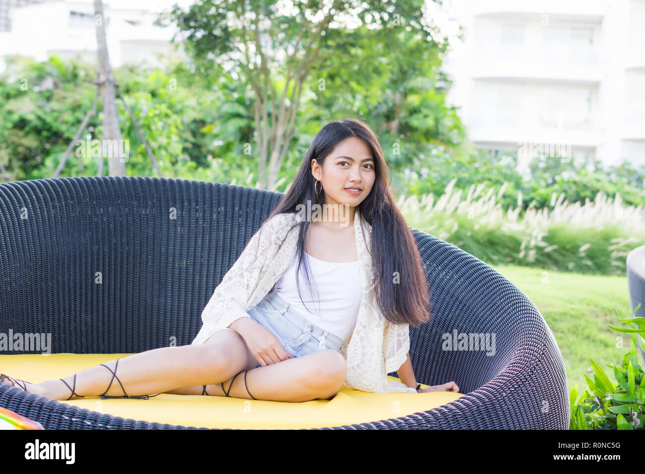 Relaxing woman sitting comfortable in sofa lounge chair smiling happy ...