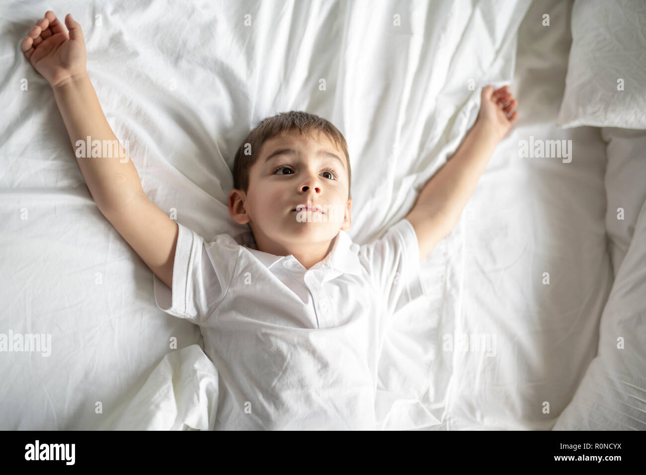 A Little boy lay on the bed with white blanket Stock Photo - Alamy