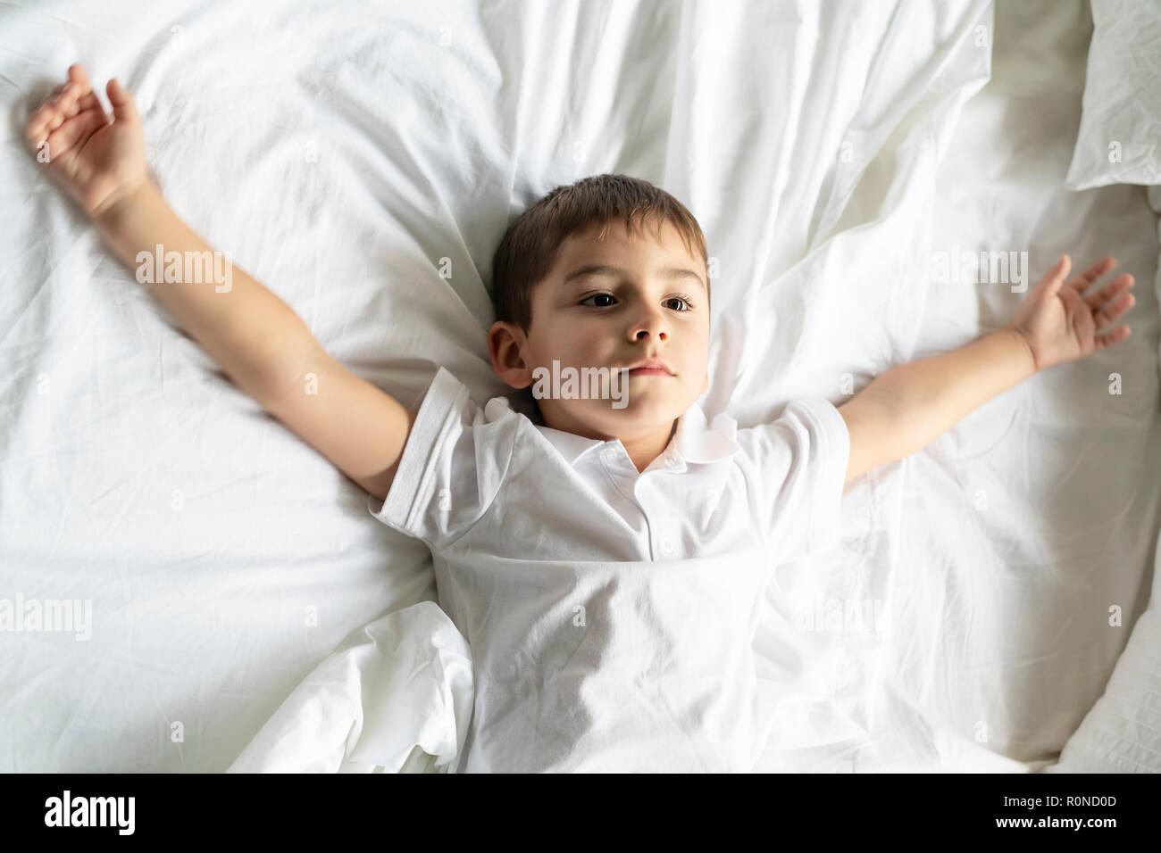 A Little boy lay on the bed with white blanket Stock Photo - Alamy